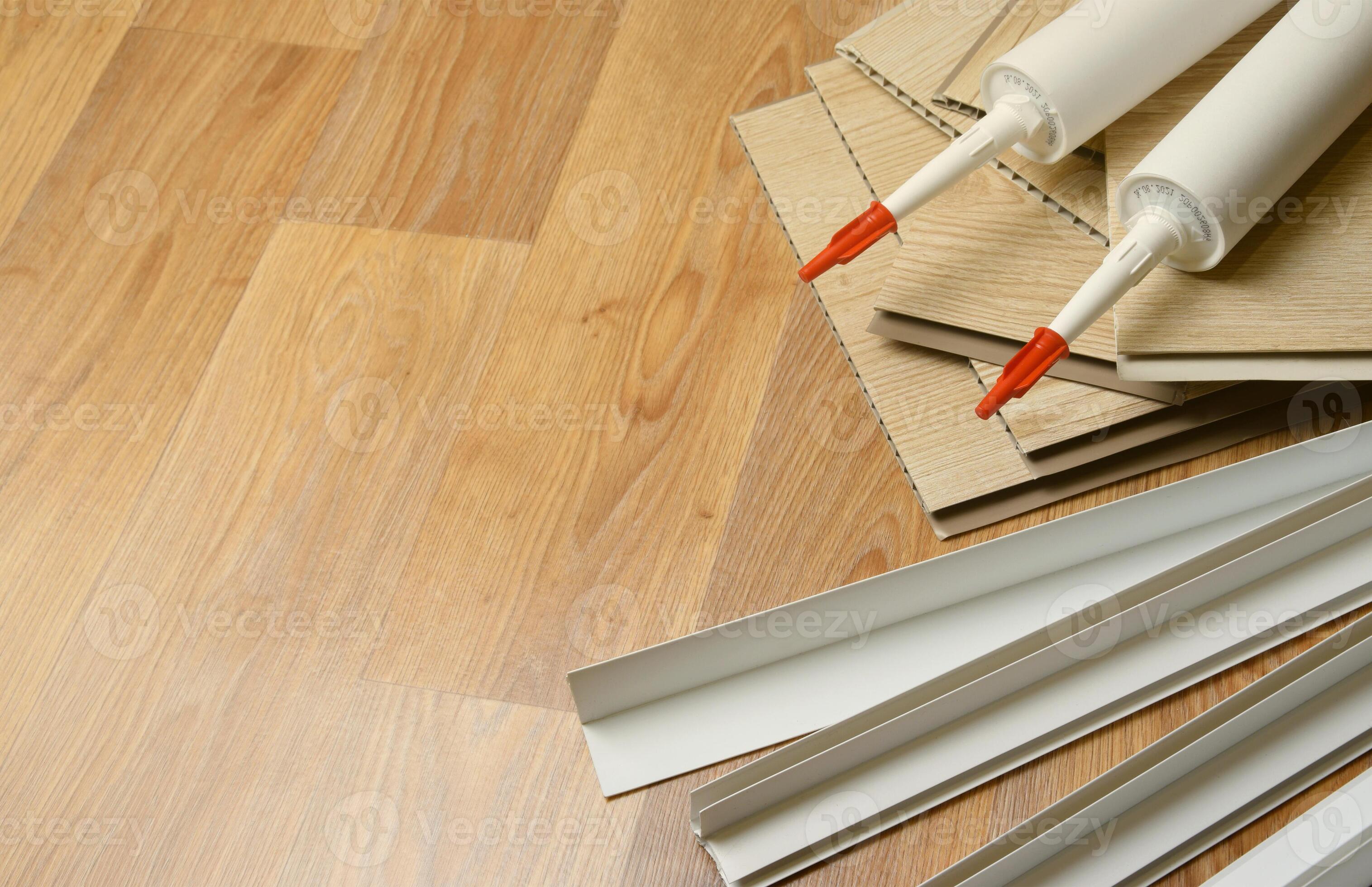 Set of items for PVC ceiling indoor works. Assembly adhesive bottles and PVC panels with plastic ...