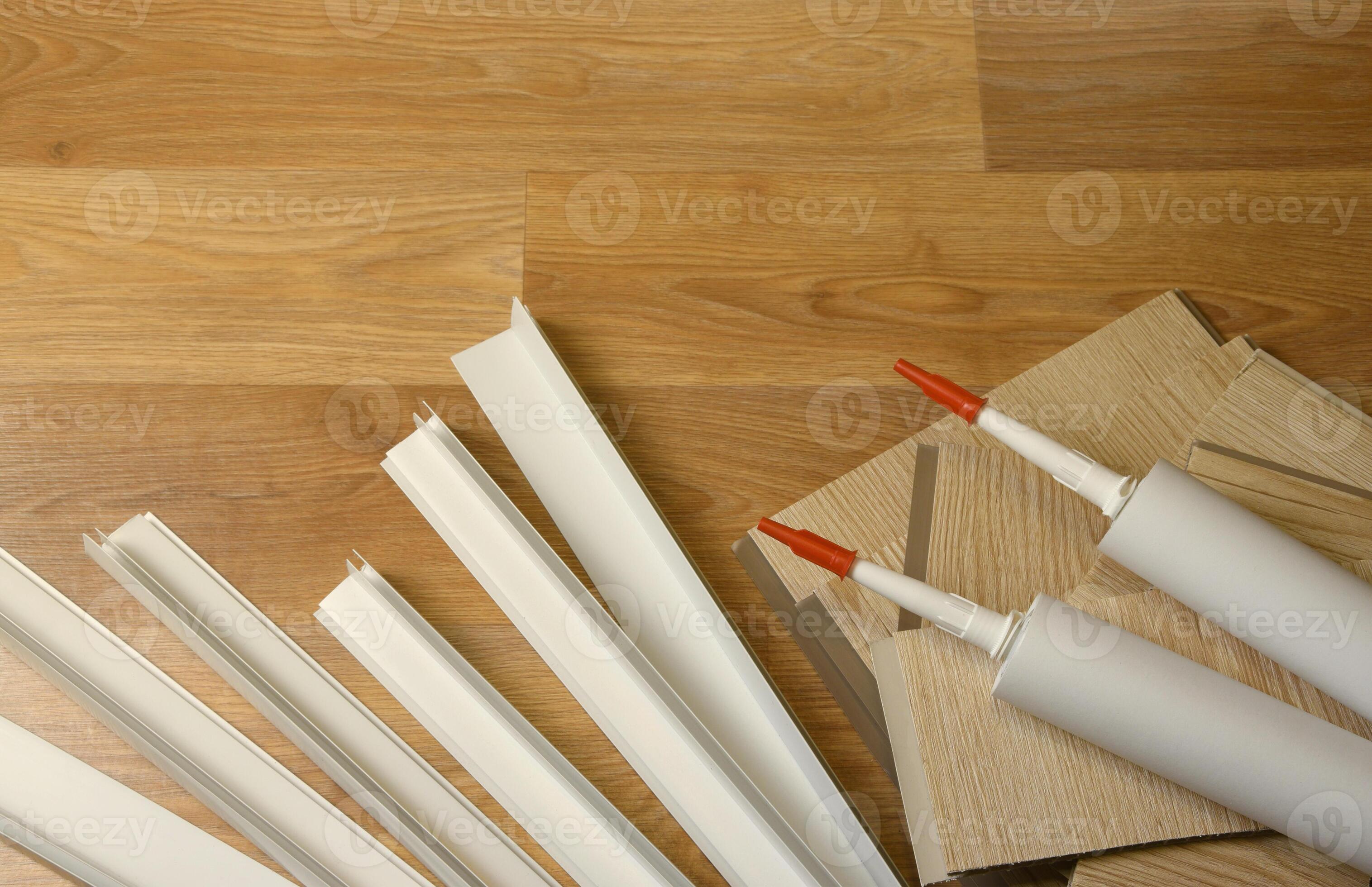 Set of items for PVC ceiling indoor works. Assembly adhesive bottles and PVC panels with plastic ...