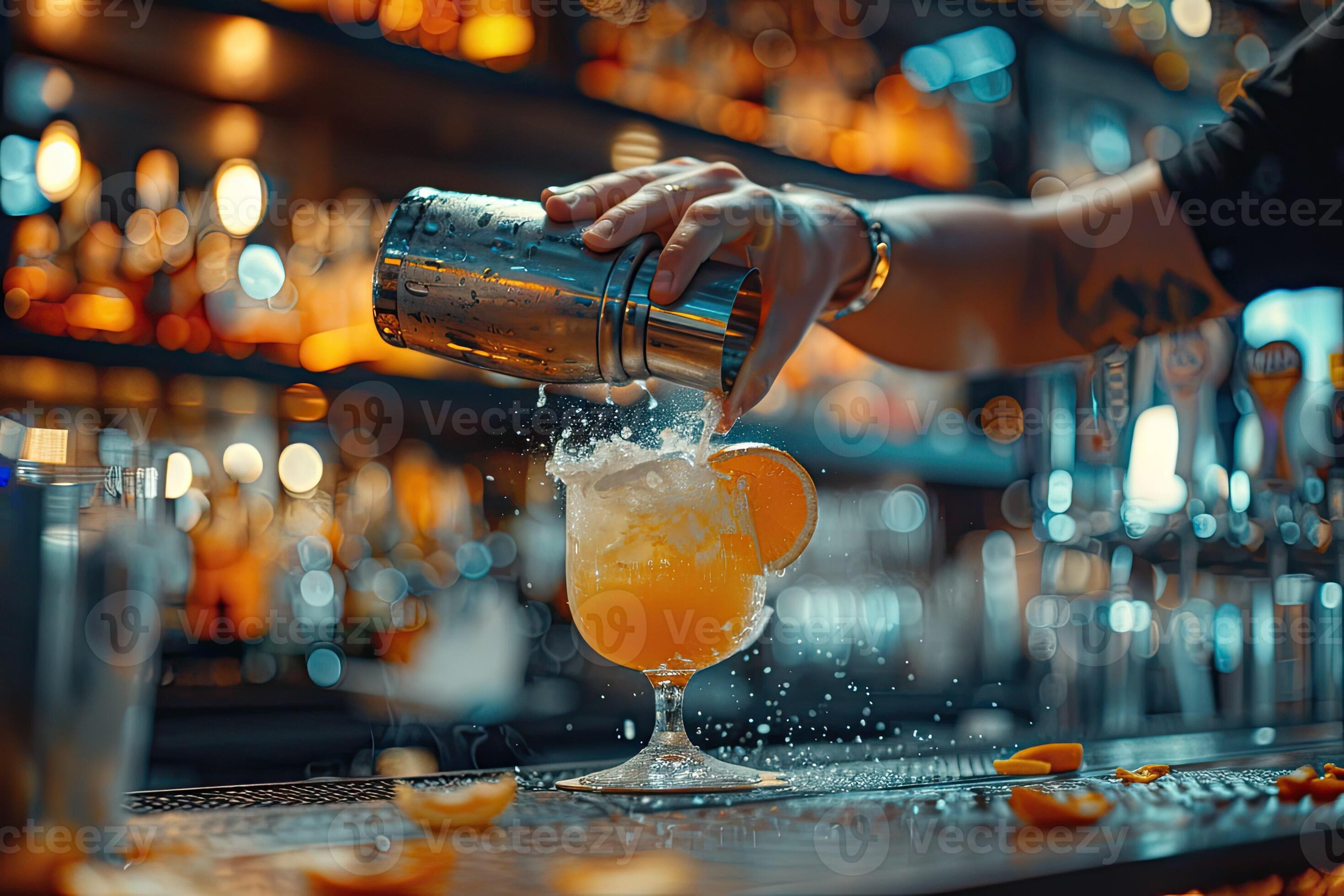 the bartender pours a cocktail from a shaker into a glass, creating a splash effect. Warm bar ...