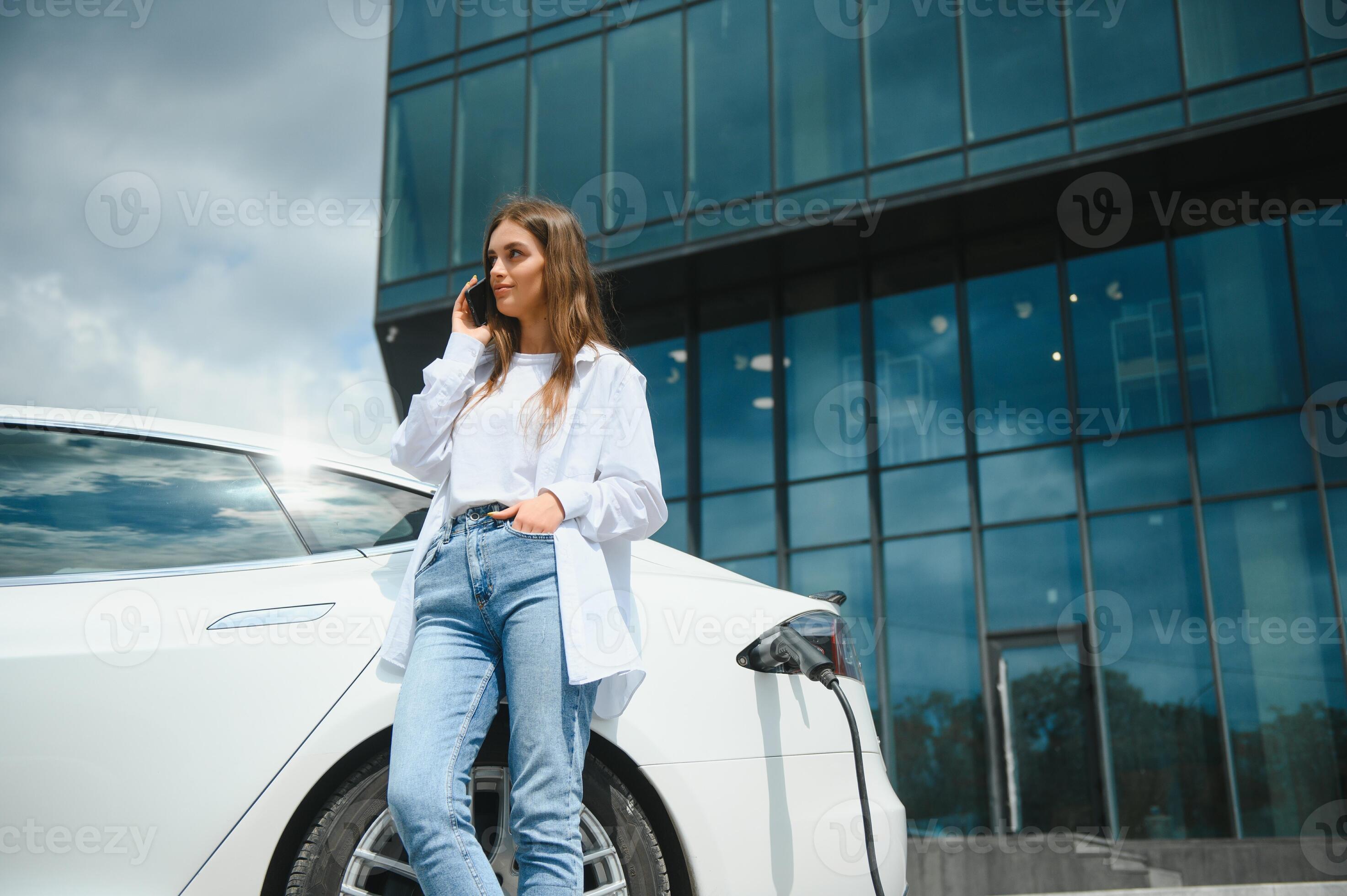 Electric car charging in street. Ecological Car Connected and Charging Batteries. Girl Waiting ...