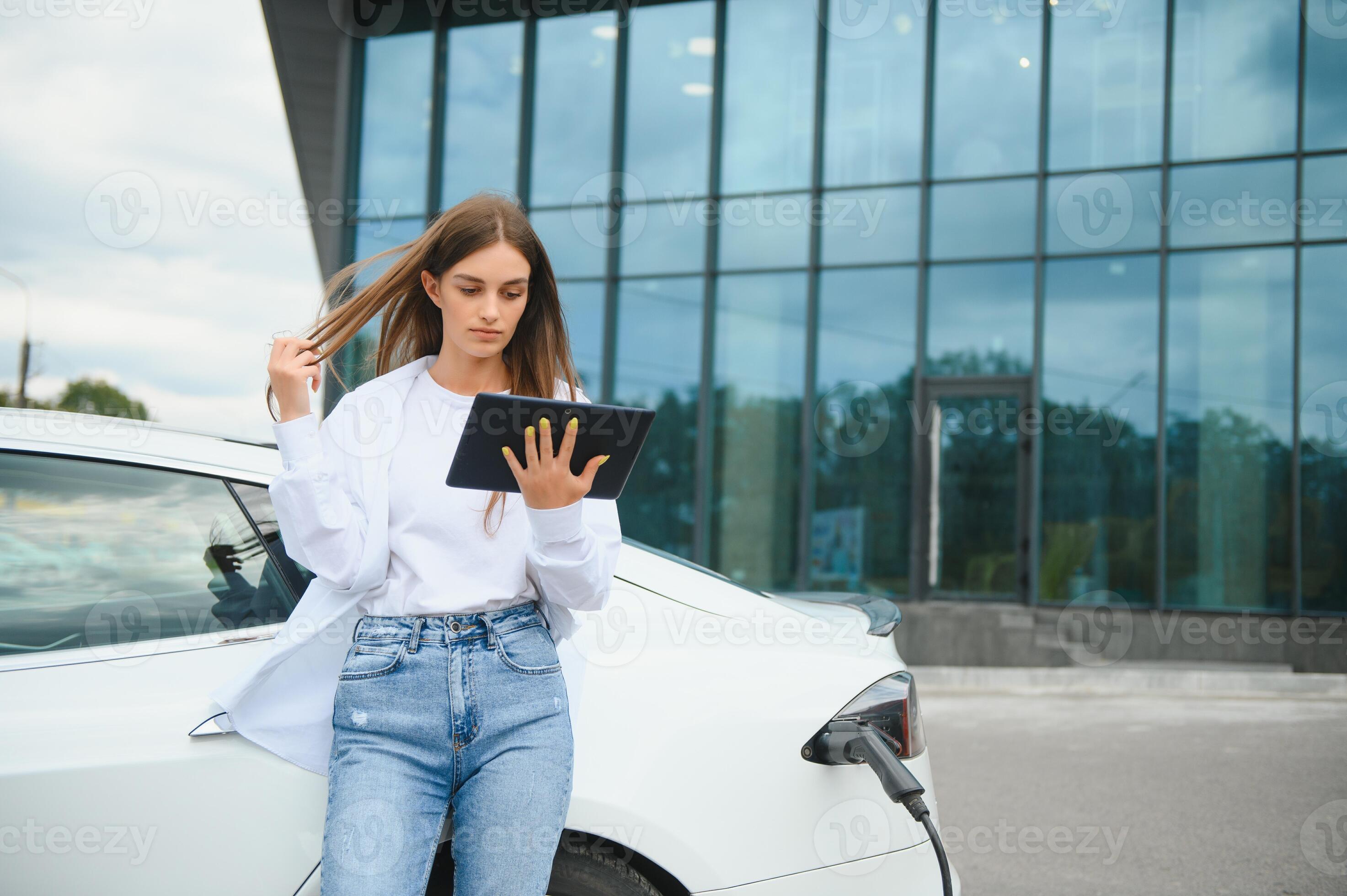 Electric car charging in street. Ecological Car Connected and Charging Batteries. Girl Waiting ...