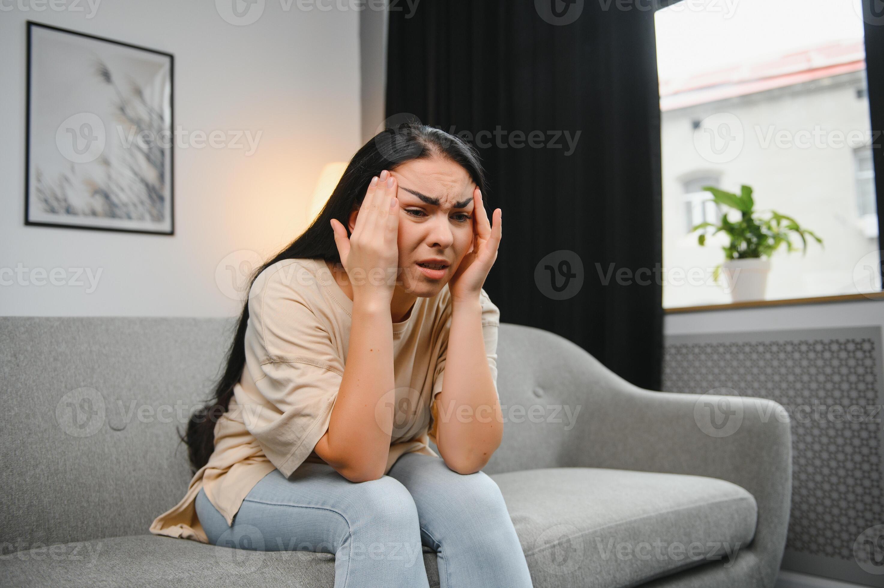 Sad tired young woman touching forehead having headache migraine or ...