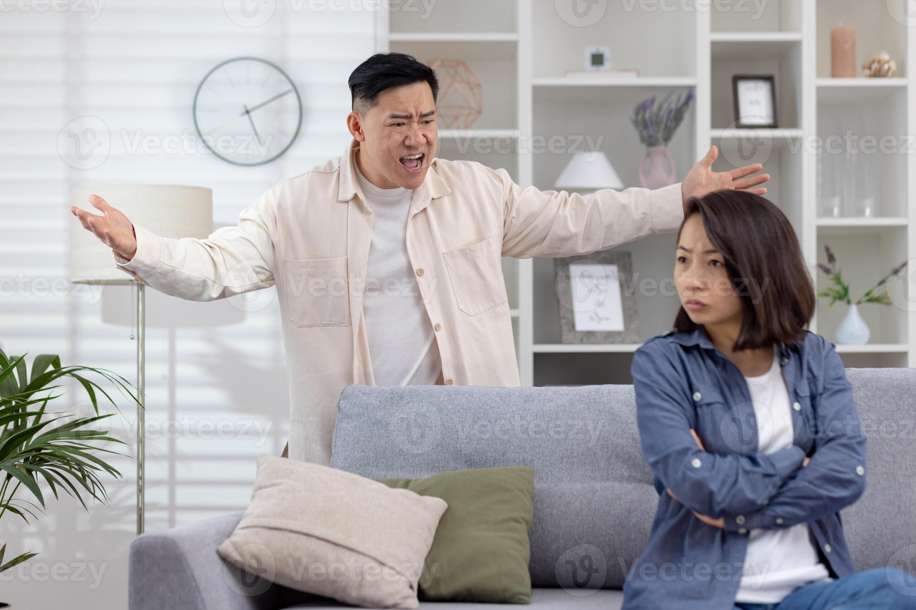 Man upset and yelling, gesturing with frustration, while a woman sits ...