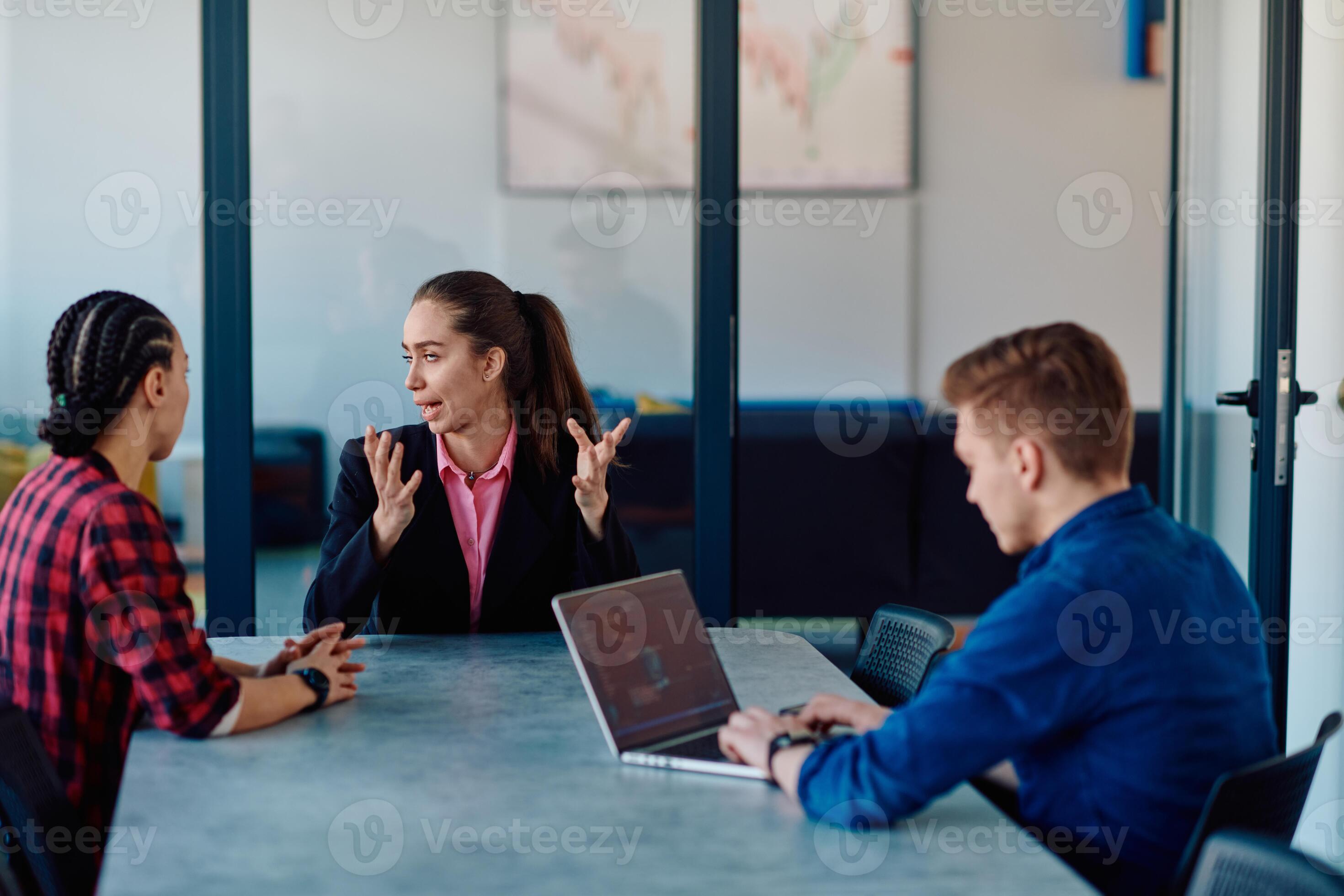 A team of successful programmers sits in a startup office, strategizing ...