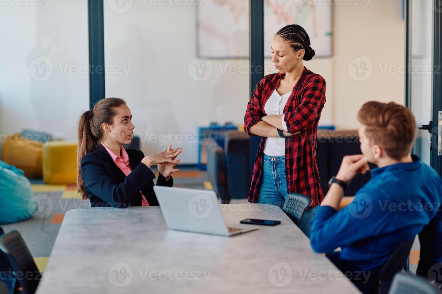 A team of successful programmers sits in a startup office, strategizing ...