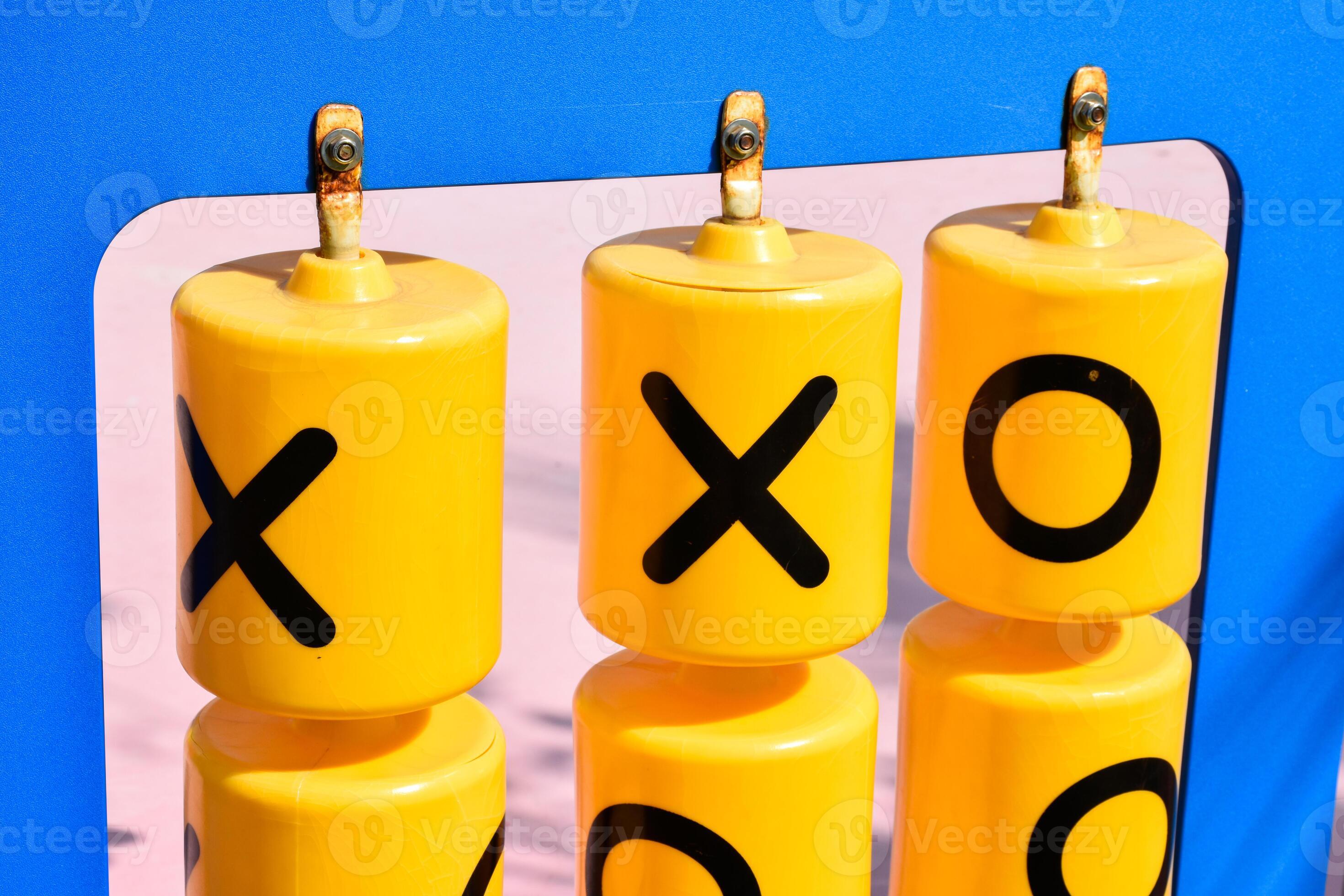 Close-up yellow plastic educational alphabet x and o black letters called tic-tac-toe game or XO ...