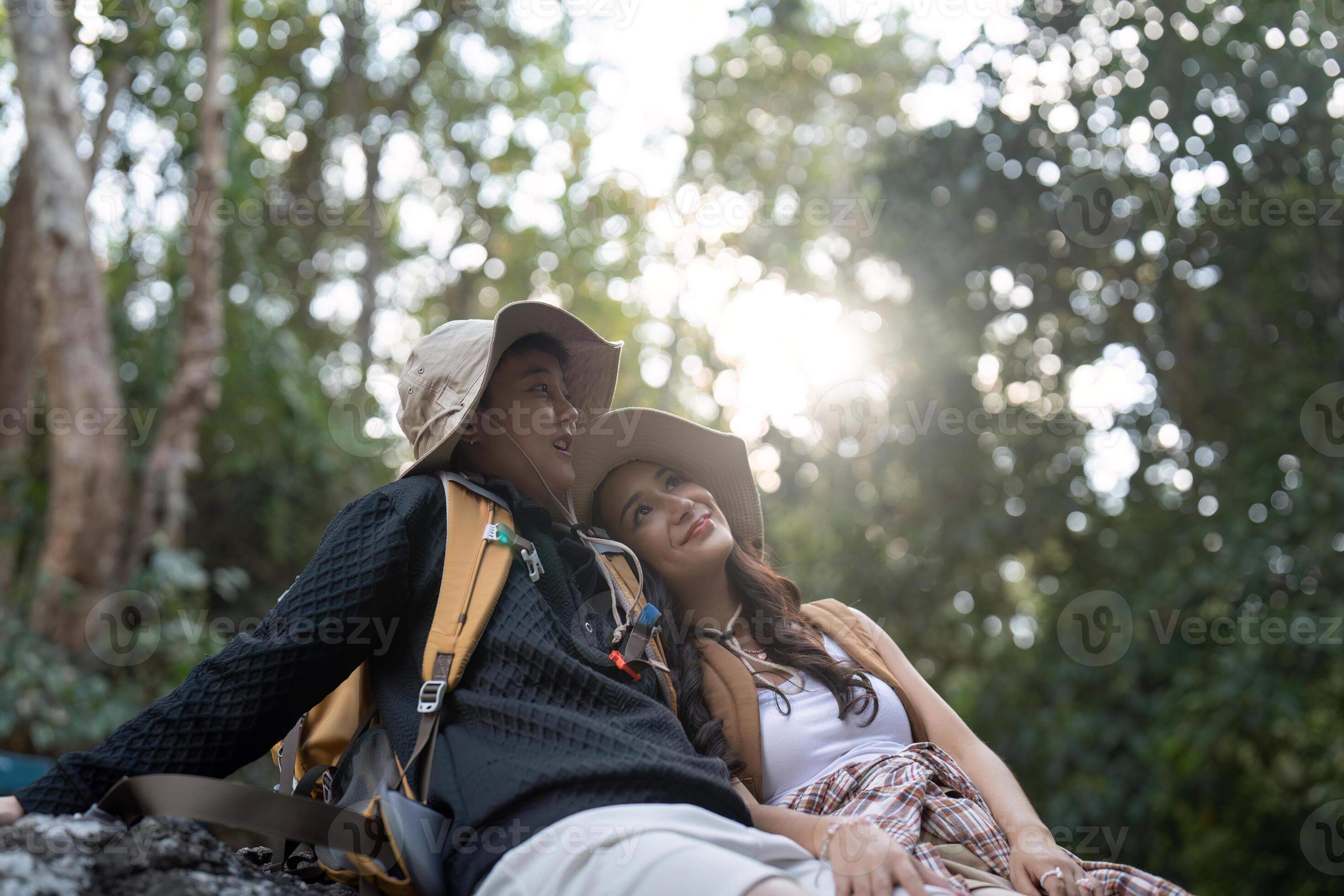 Lovely couple lesbian woman with backpack relaxing while hiking in nature. Loving LGBT romantic ...