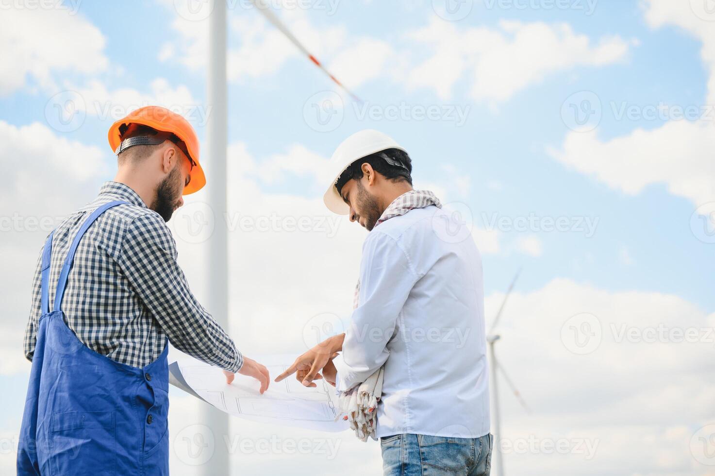 Two Engineers Discussing Against Turbines On Wind Turbine Farm