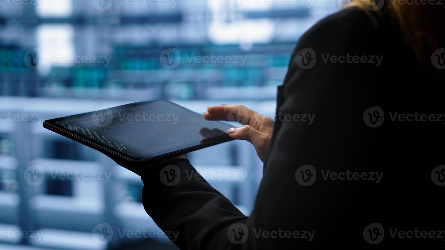 System administrator monitoring server room, doing checkup, inputting data on tablet of needed ...