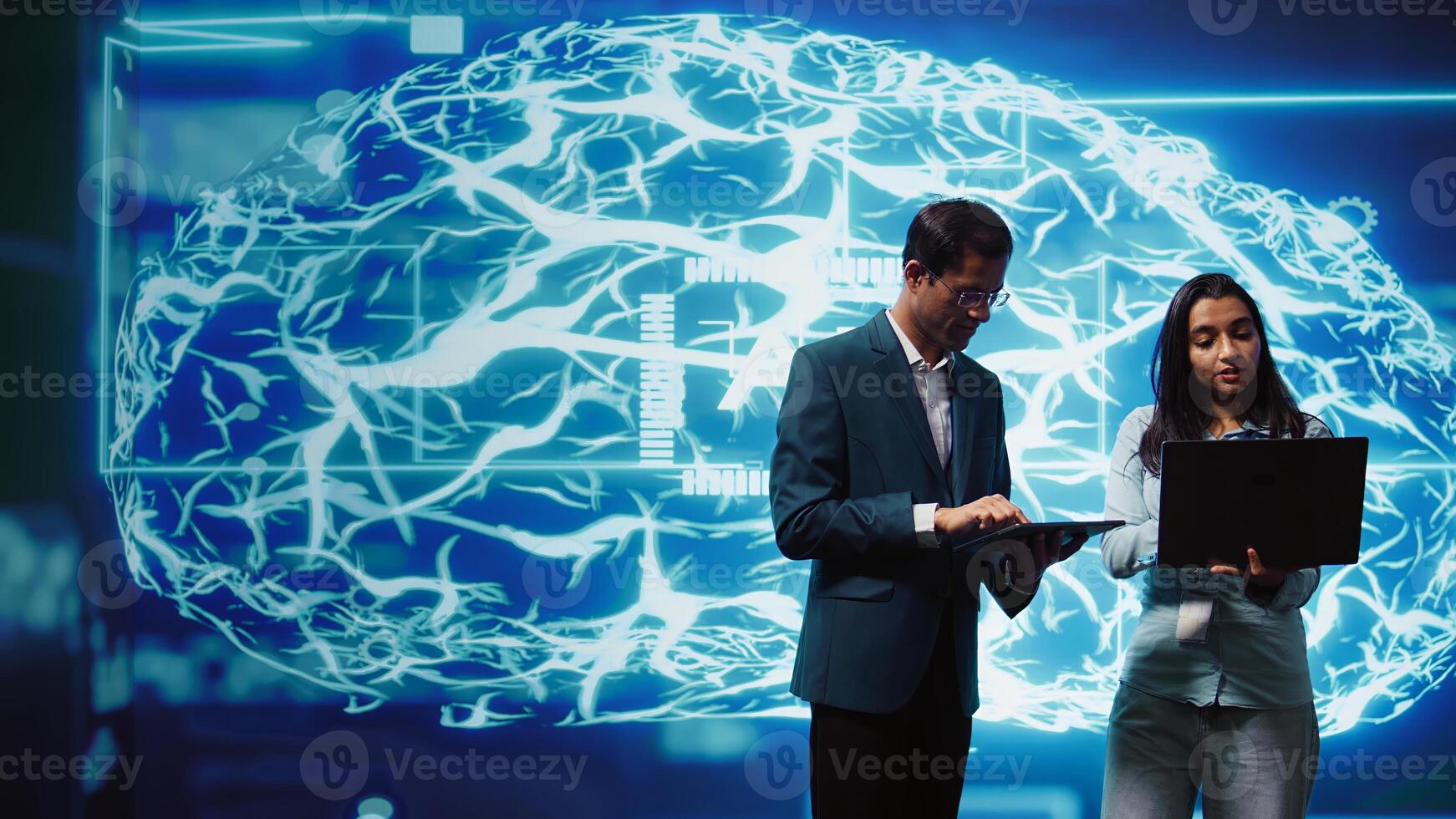 IT department colleagues solving tasks on laptop and tablet, running artificial intelligence ...