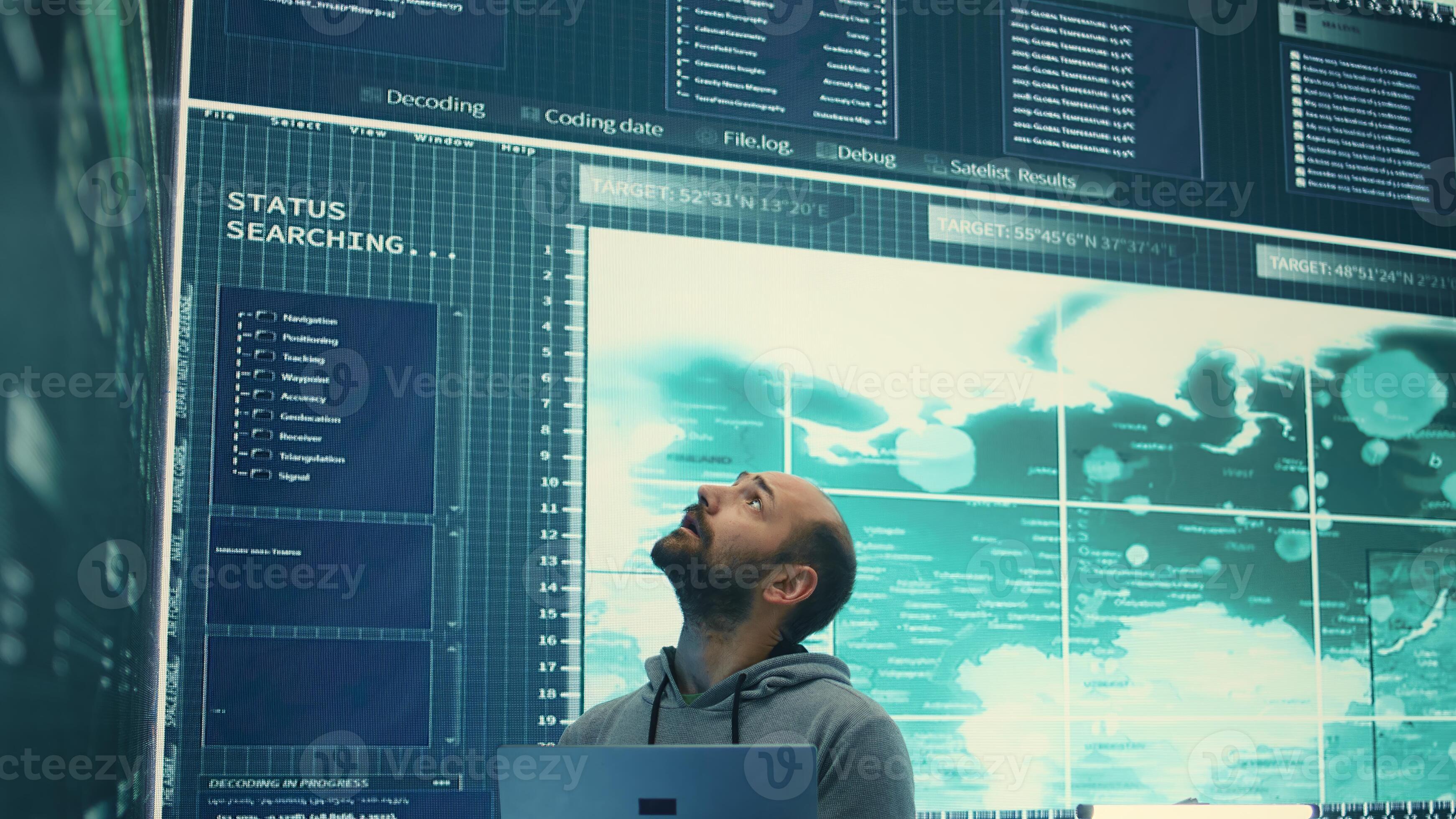 Governmental hacker examines info on a big screen in agency office ...