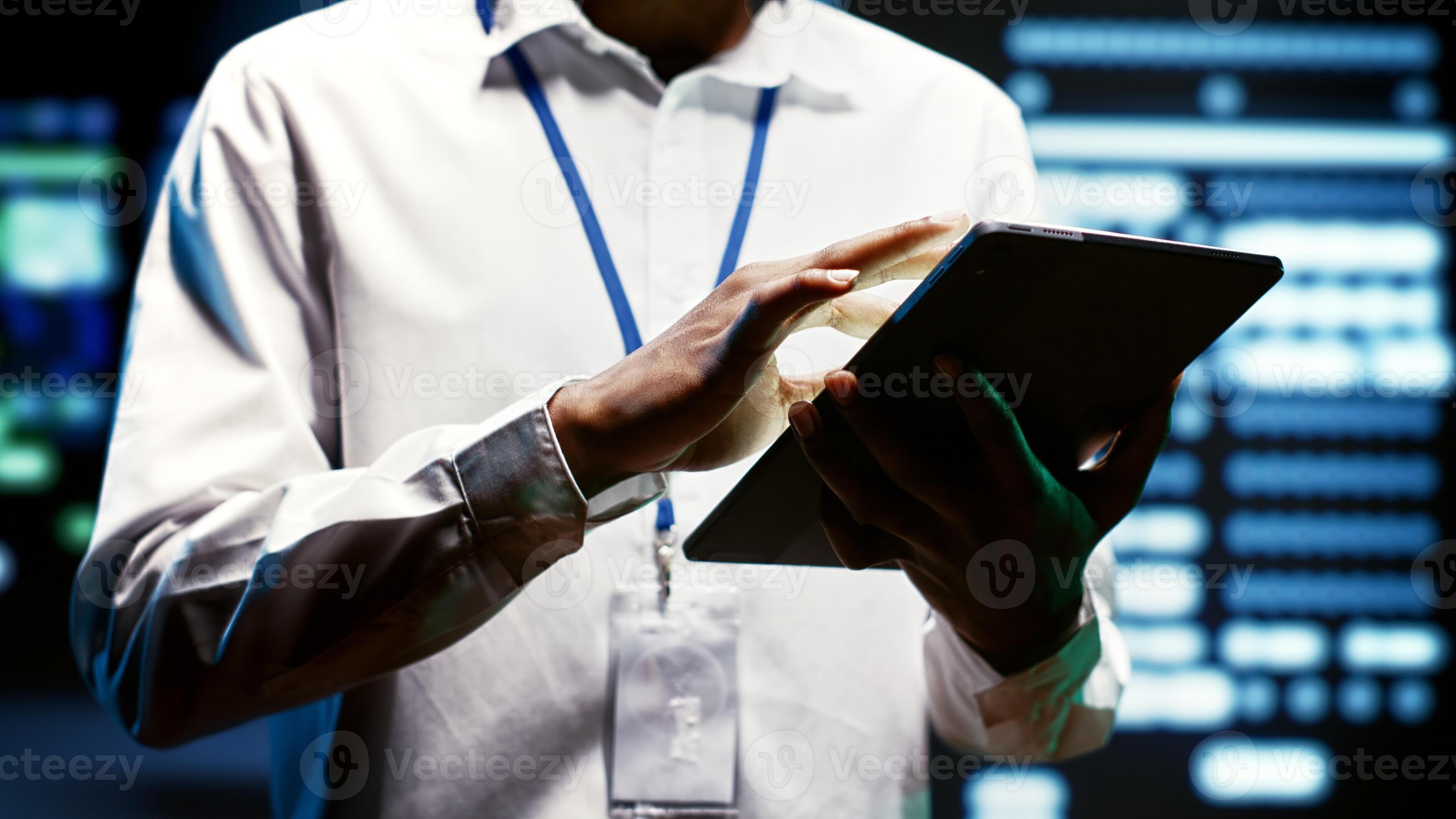Worker using tablet to do assessments of data center rackmounts doing ...