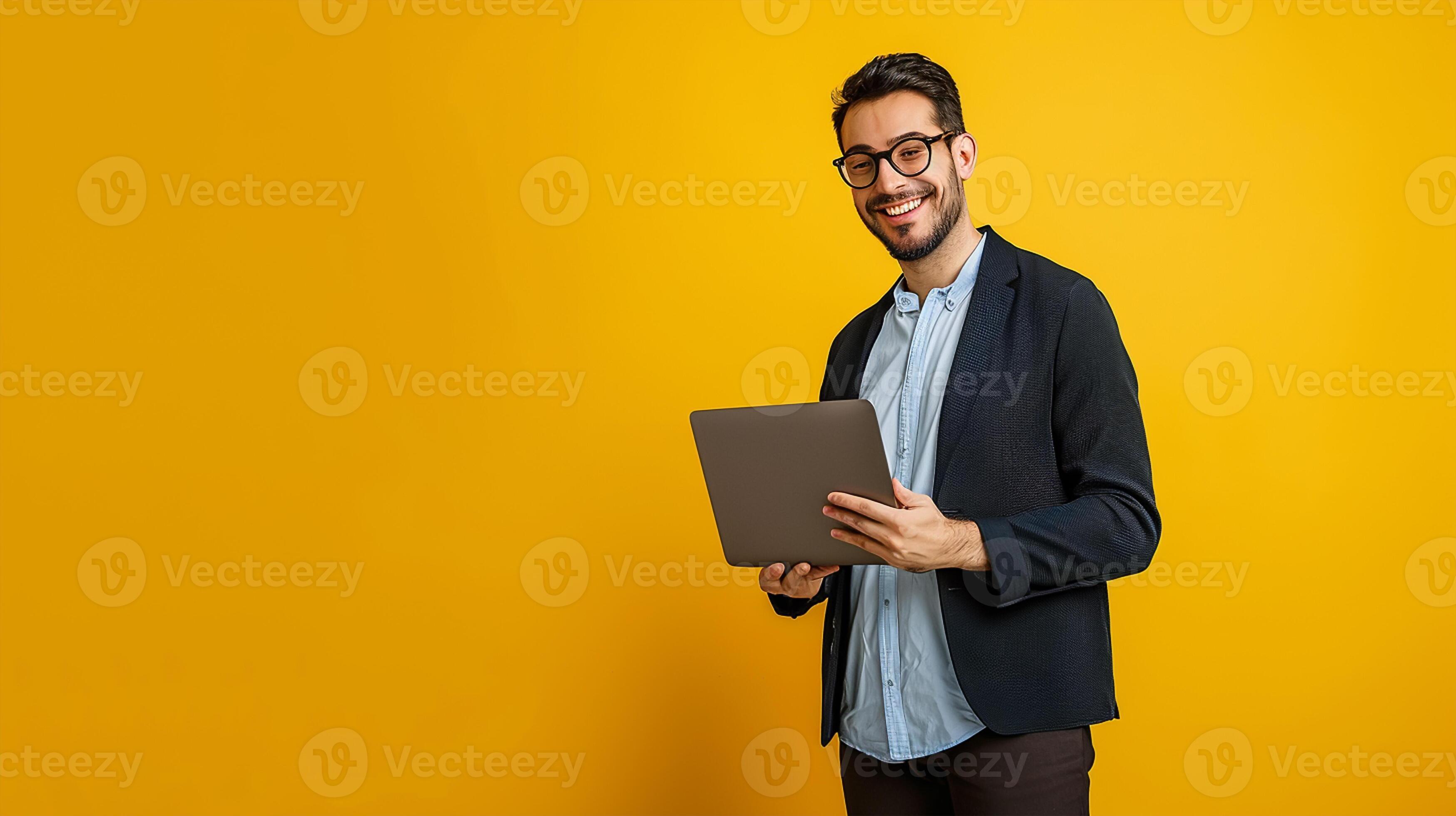 Smiling Businessman Wearing Eyeglasses Working On Laptop While Standing On Yellow Background