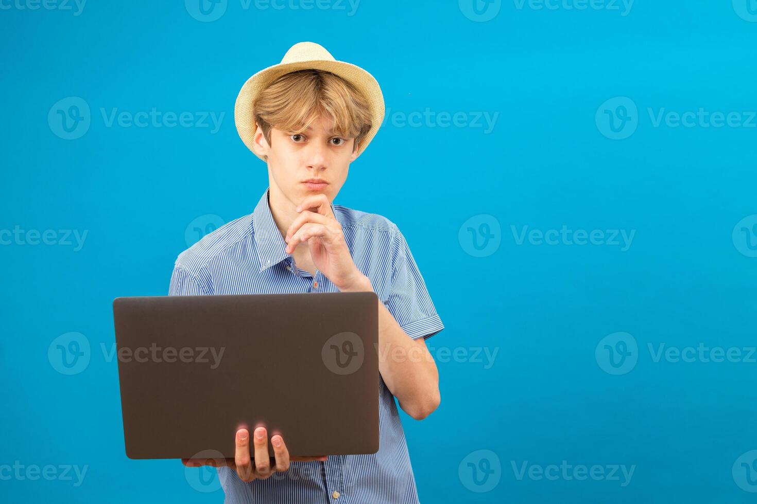 Serious businessman teen holding laptop in hands and typing. Blogger making posts in social ...