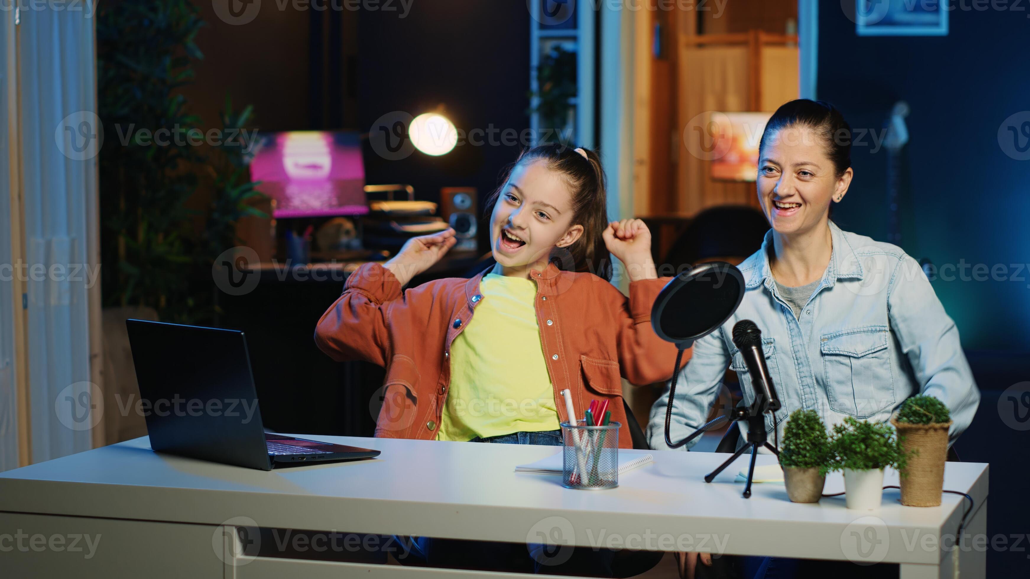 Young girl and her mother using recording devices to shoot intro for family vlog channel on ...