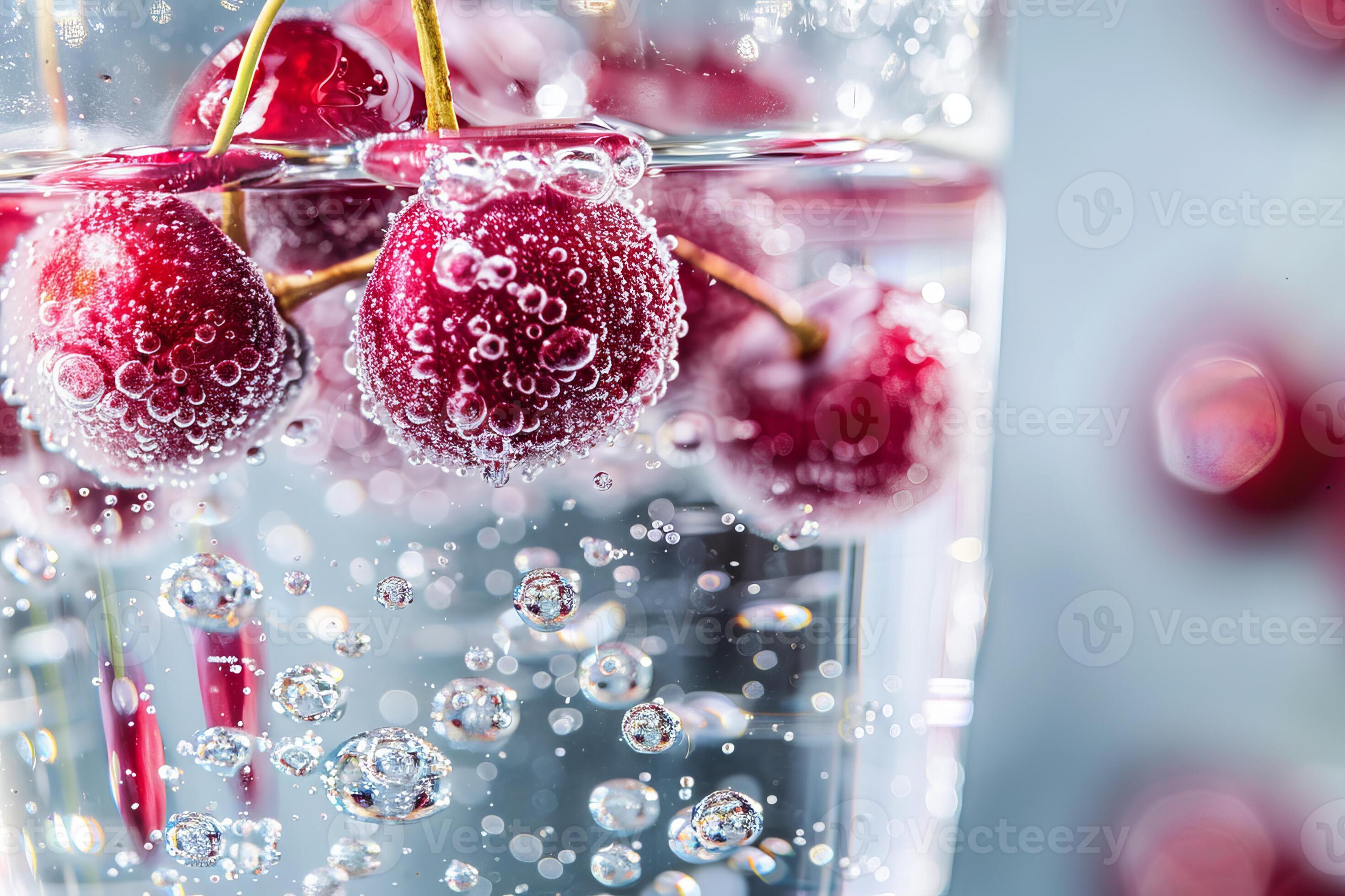Fresh red cherries with stems are floating in a glass of sparkling water with bubbles 47908909 ...