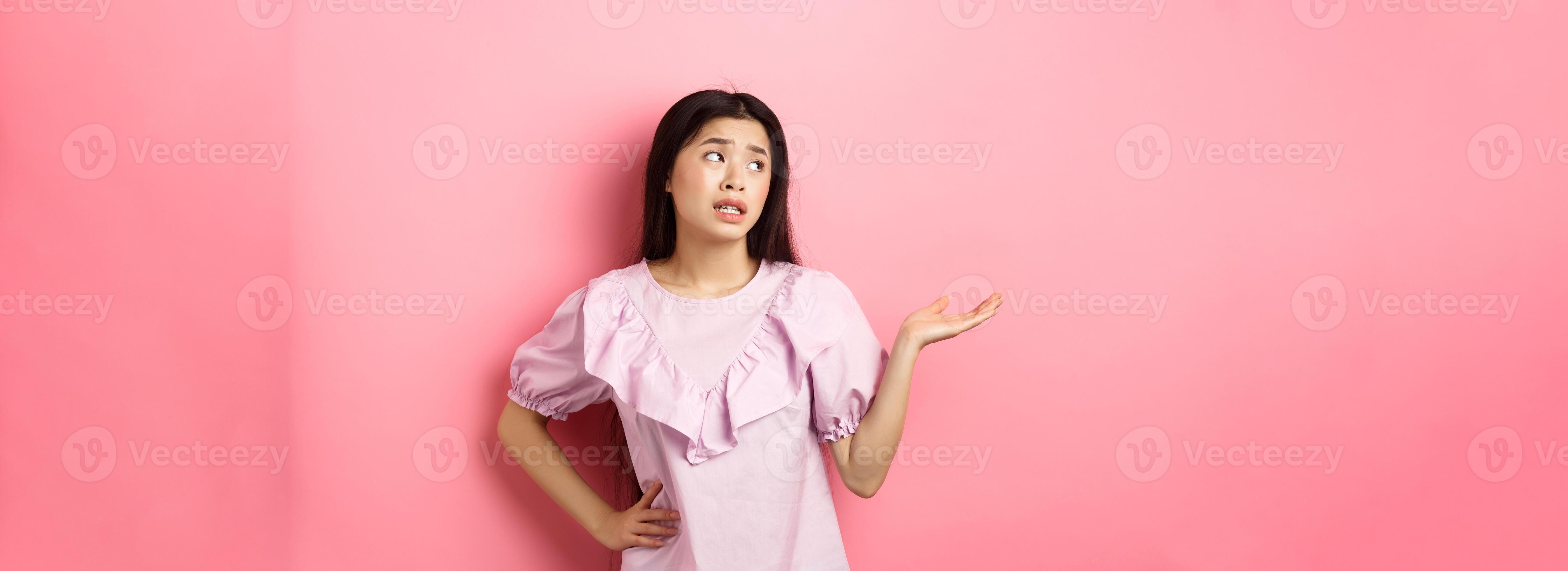 Ignorant asian woman look away and shrugging careless, raising hand up ...