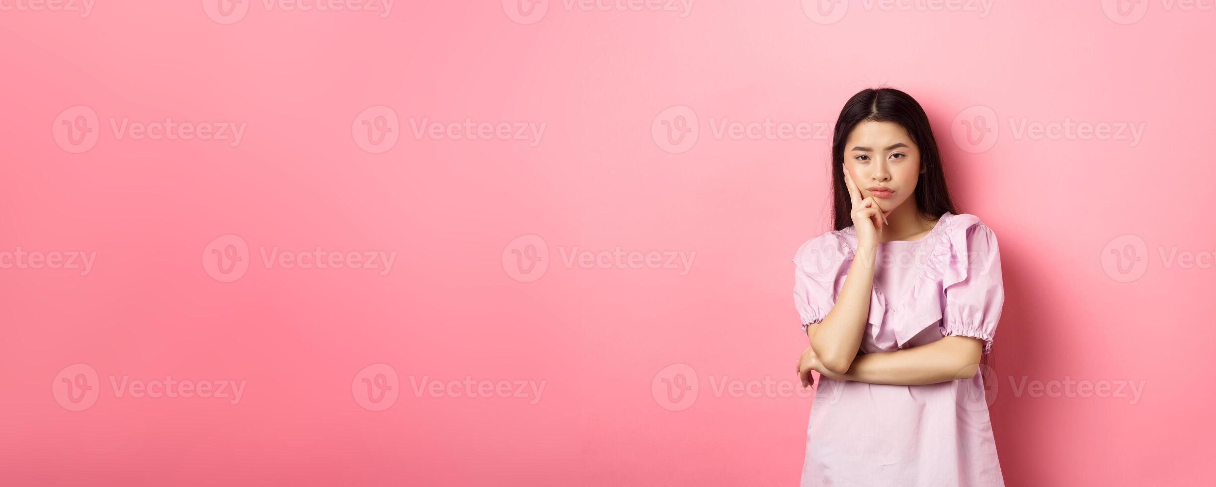 Bored asian teen girl look indifferent at camera, lean face on hand in ...