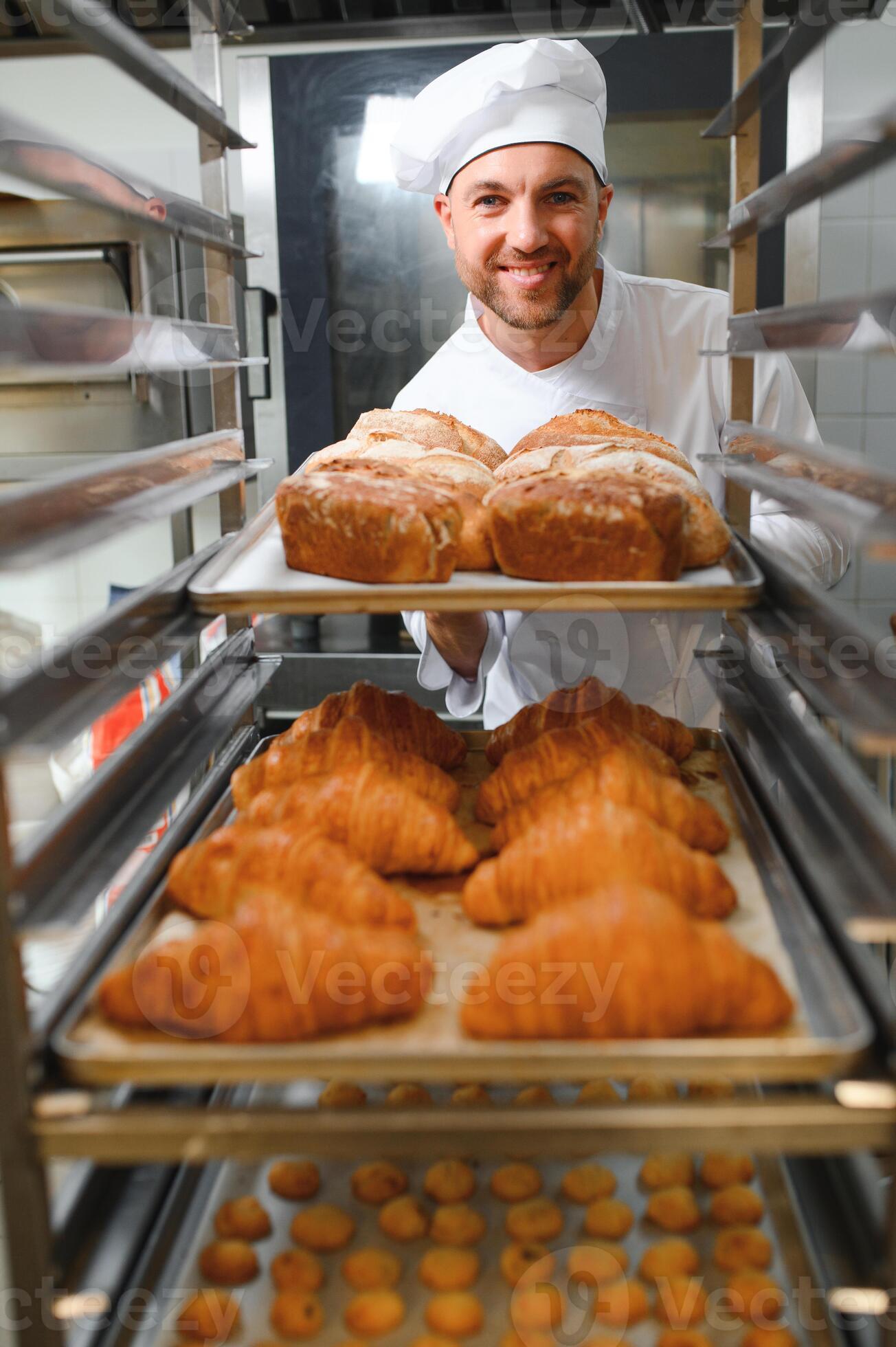 Male baker holding board with assortment of fresh bread in shop 47967560 Stock Photo at Vecteezy