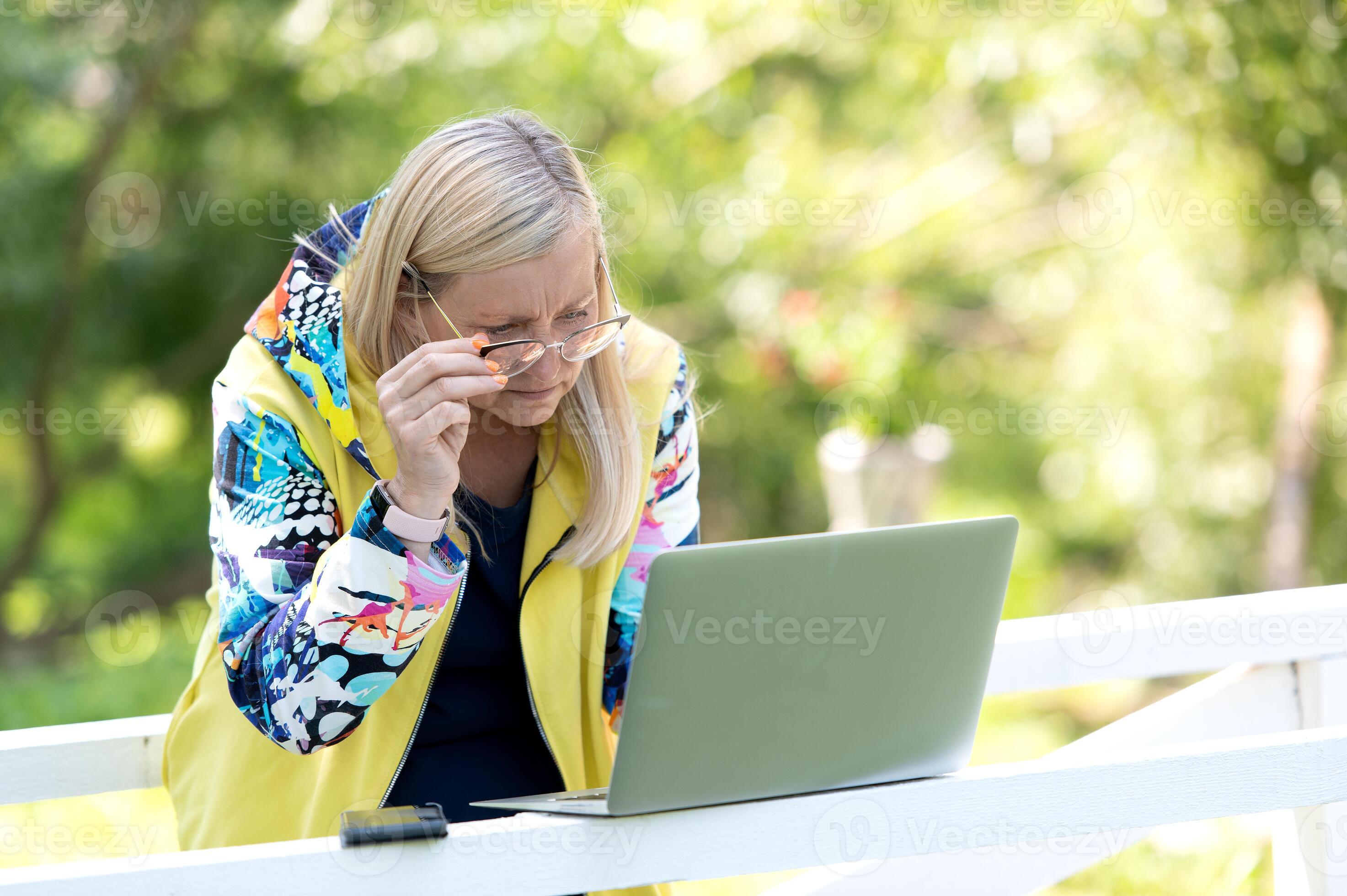 Emotional middle-aged blonde business woman solves work issues using ... Emotional middle-aged blonde business woman solves work issues using ...