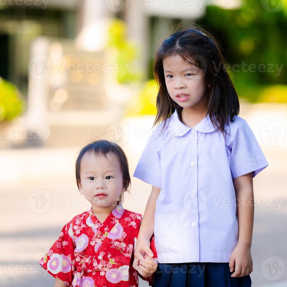 Asian older sister and young brother enjoy a joyful moment together ...