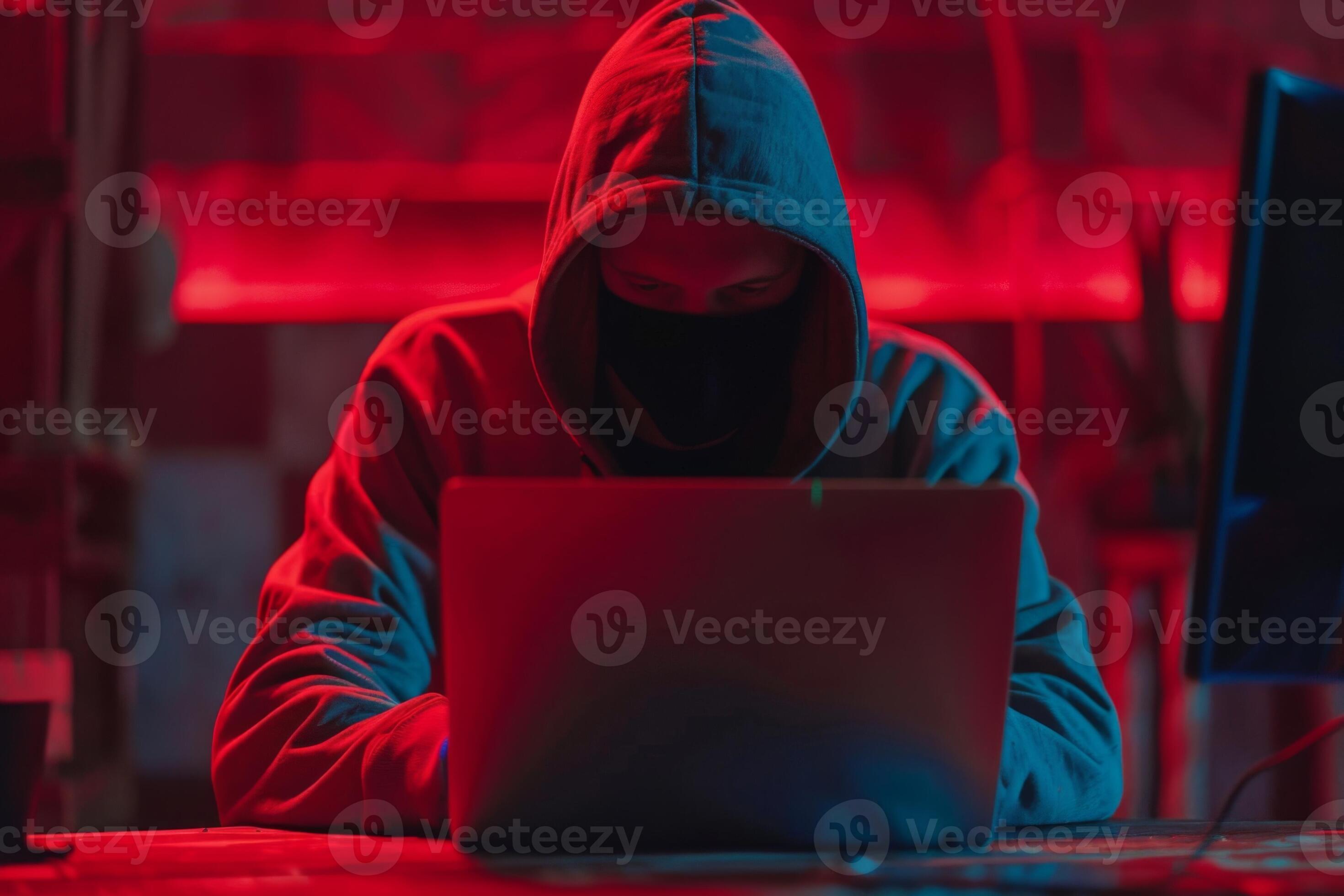 Hacker In Hood Hacking At Computer In Dark Room Computer Criminal Uses Malware To Hack Devices
