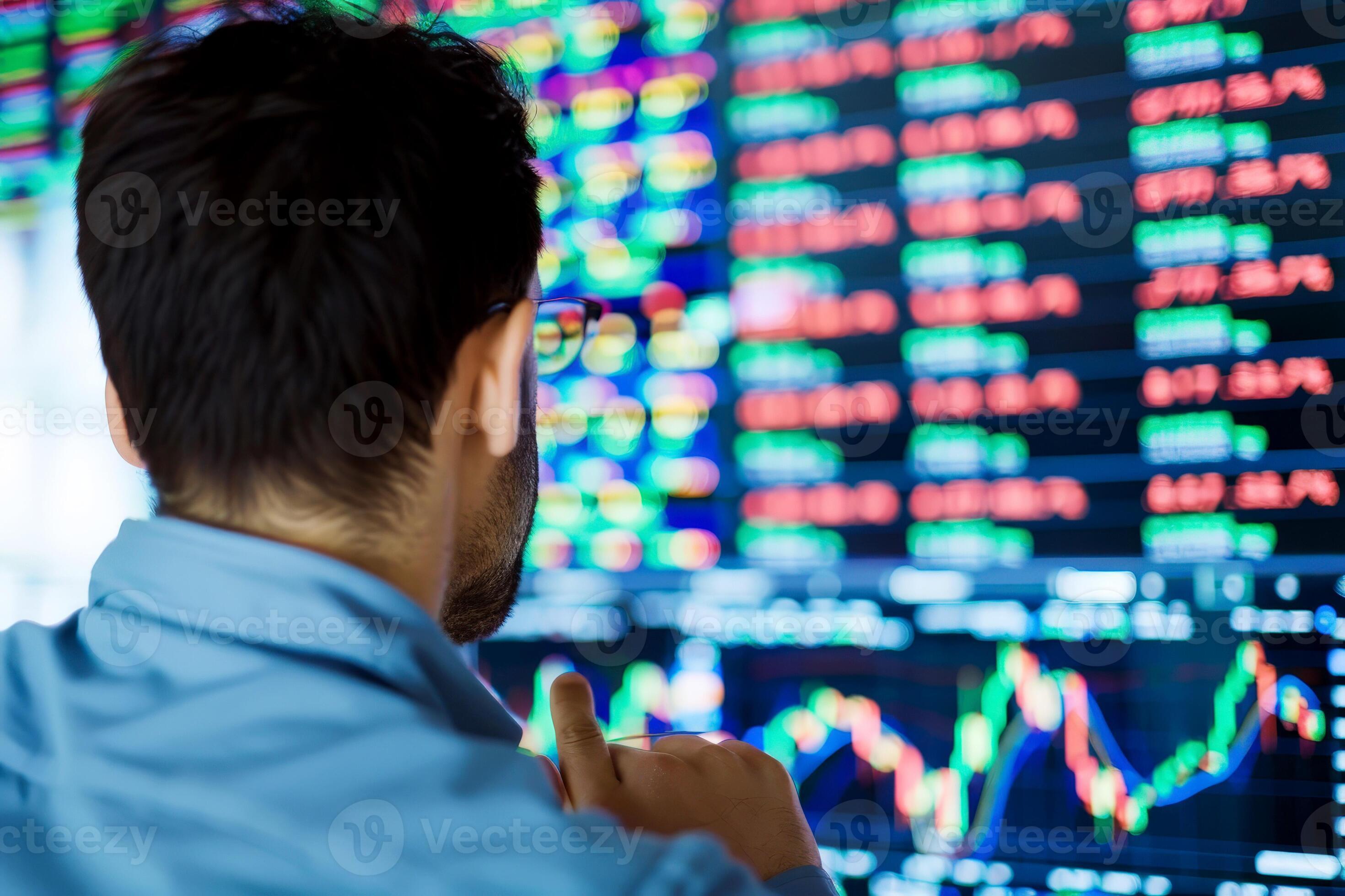 Businessman Analyzing Stock Market Data On Multiple Monitors In A