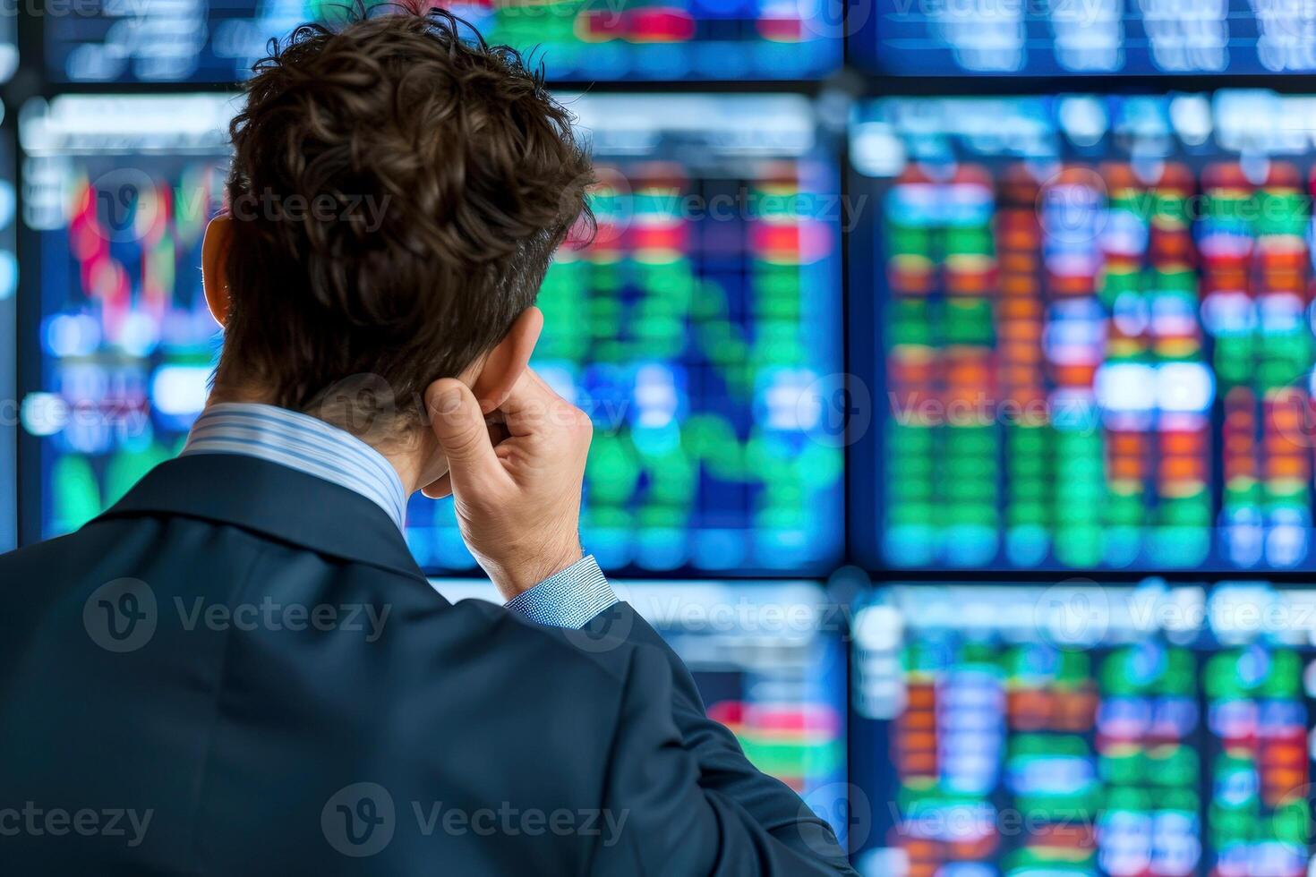 Businessman analyzing stock market data on multiple monitors in a ...