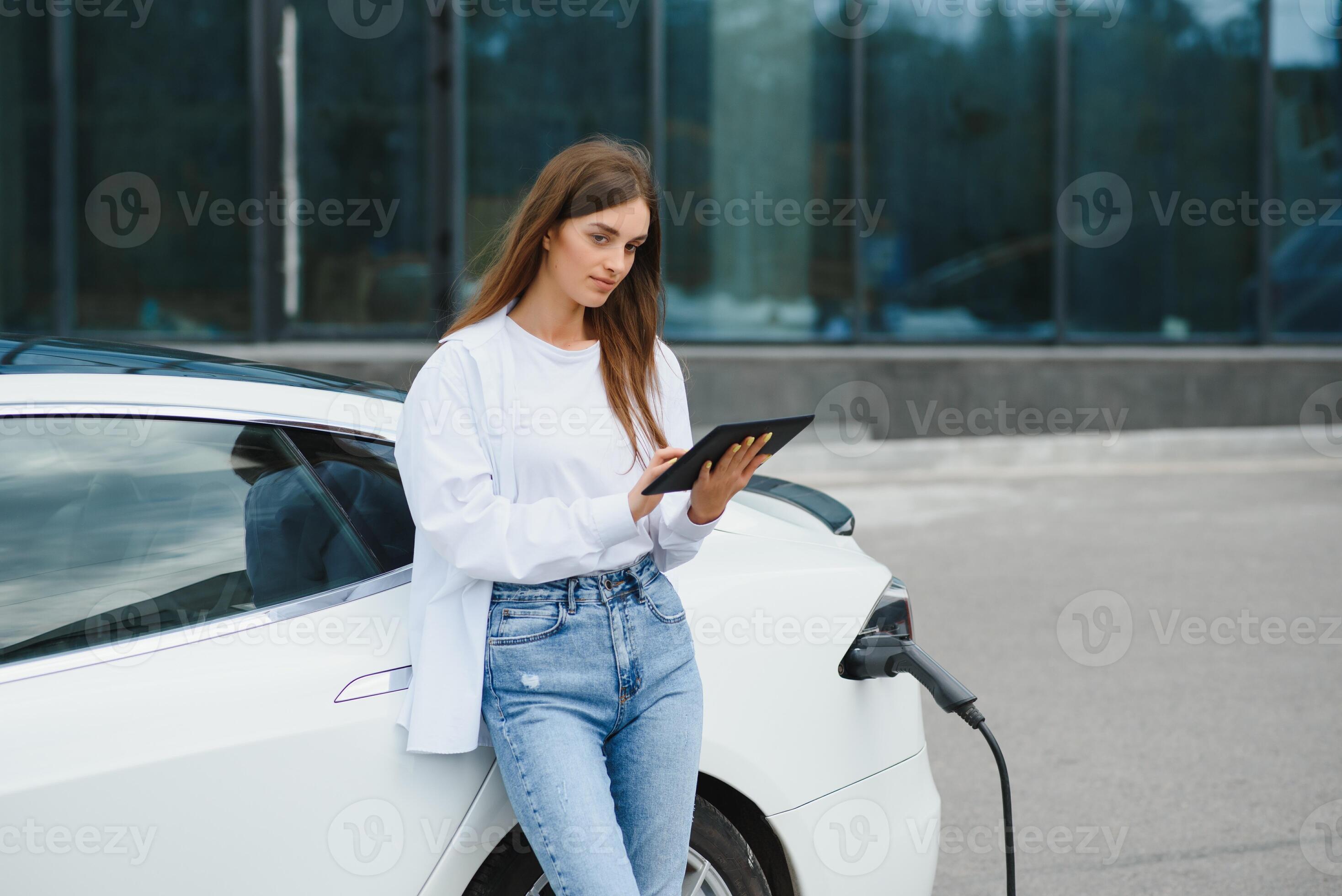 Electric car charging in street. Ecological Car Connected and Charging Batteries. Girl Waiting ...