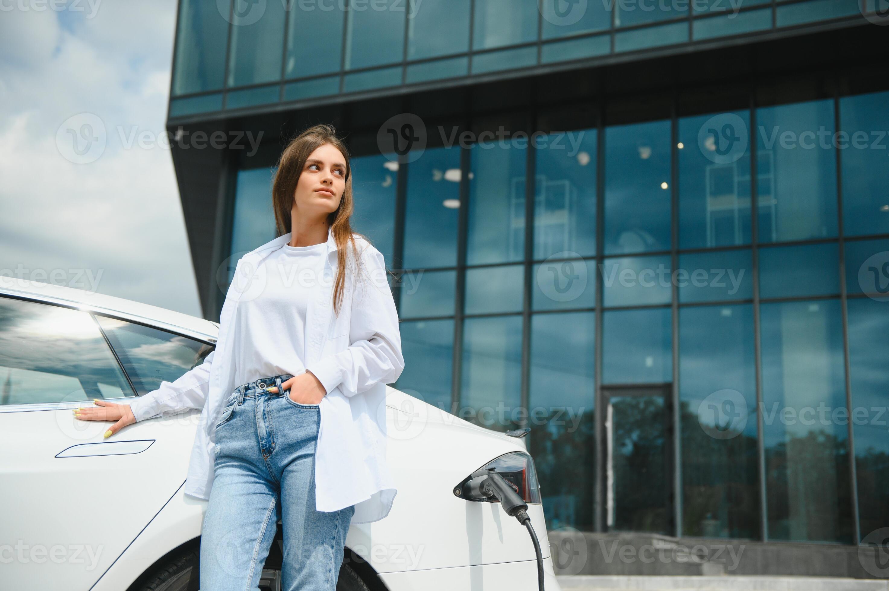 Electric car charging in street. Ecological Car Connected and Charging Batteries. Girl Waiting ...