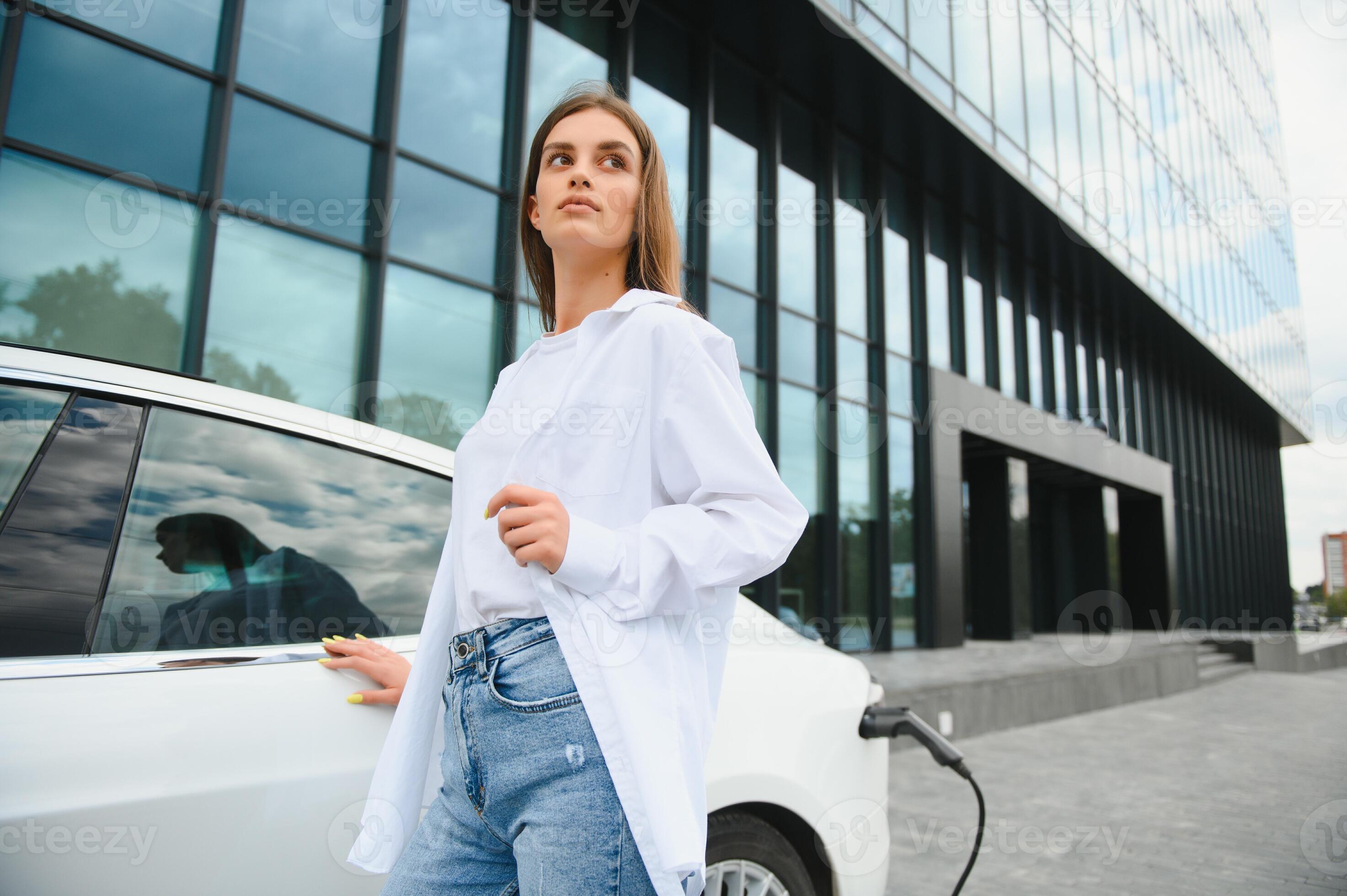 Electric car charging in street. Ecological Car Connected and Charging Batteries. Girl Waiting ...