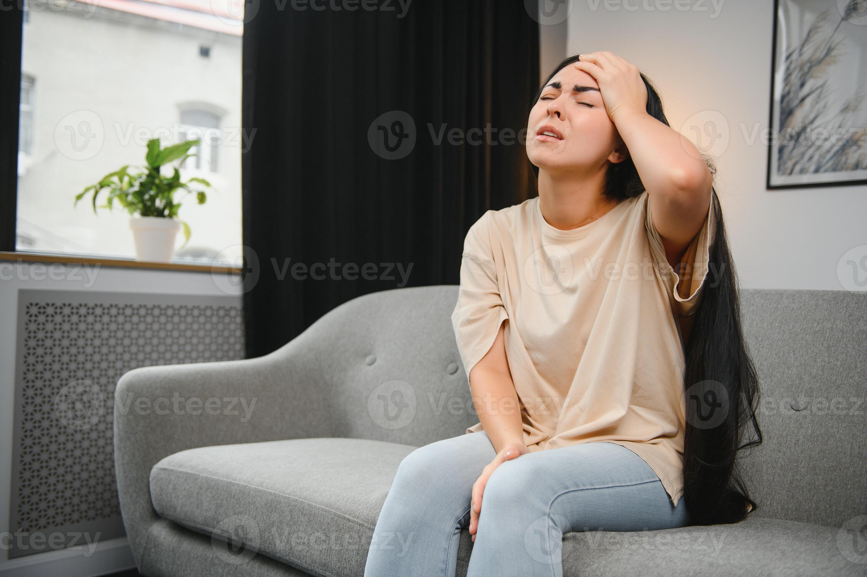 Sad tired young woman touching forehead having headache migraine or ...