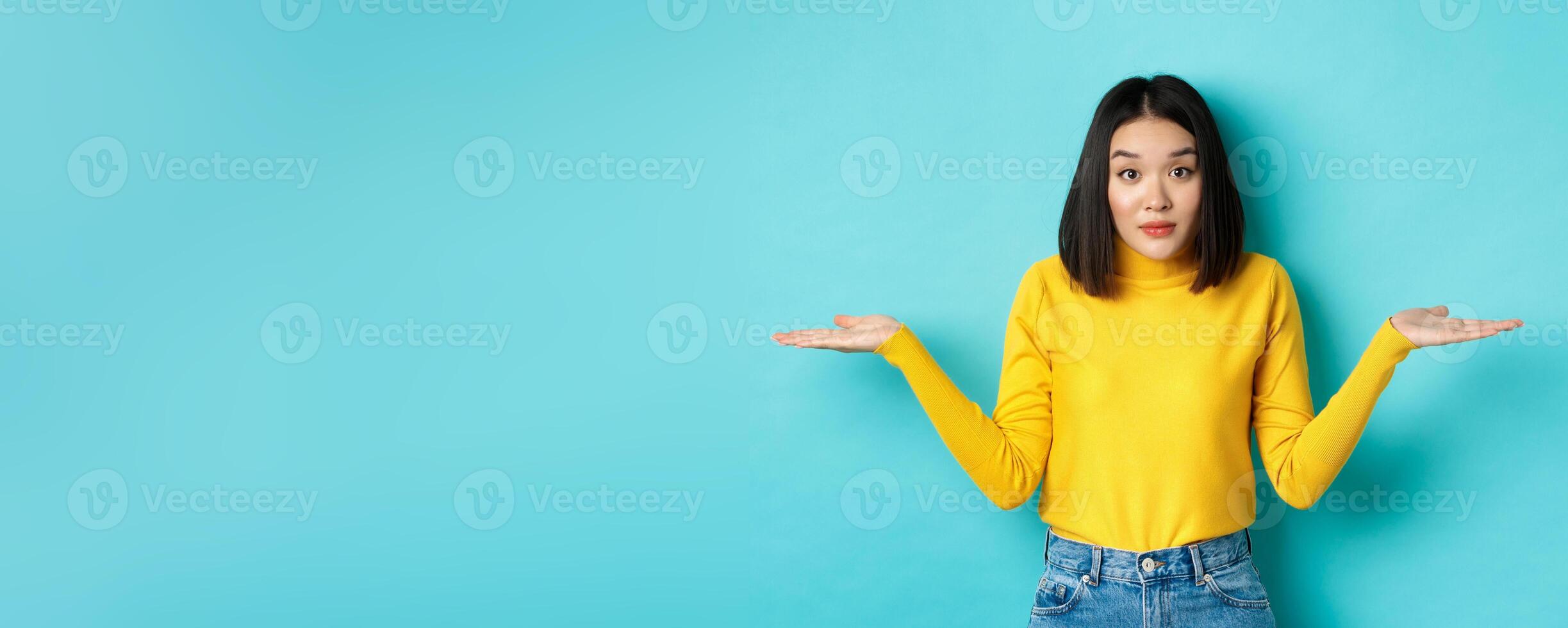 Image of indecisive asian woman shrugging shoulders, spread hands ...