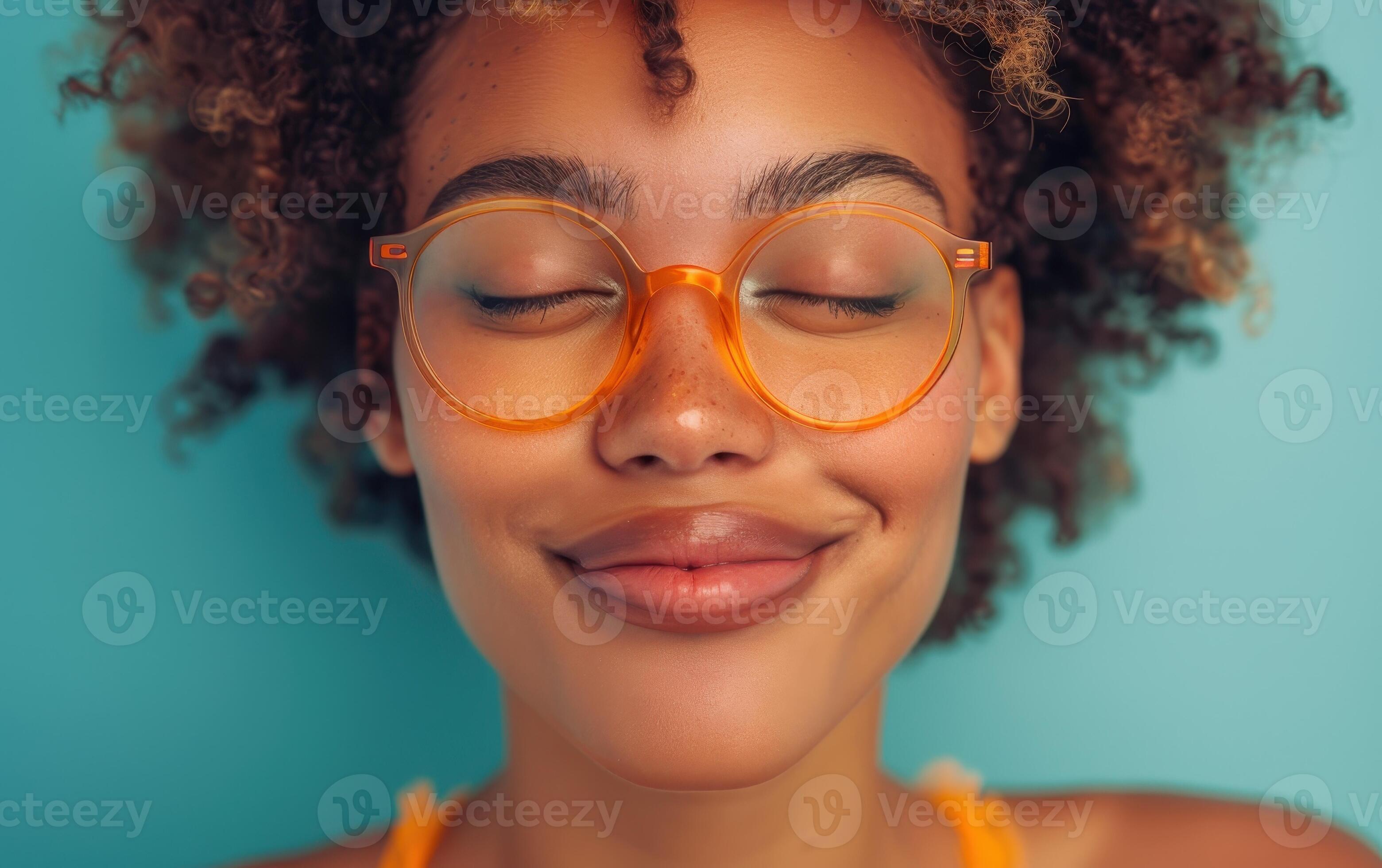Smiling Woman With Eyes Closed Wearing Round Orange Glasses Against A Teal Background 48305640