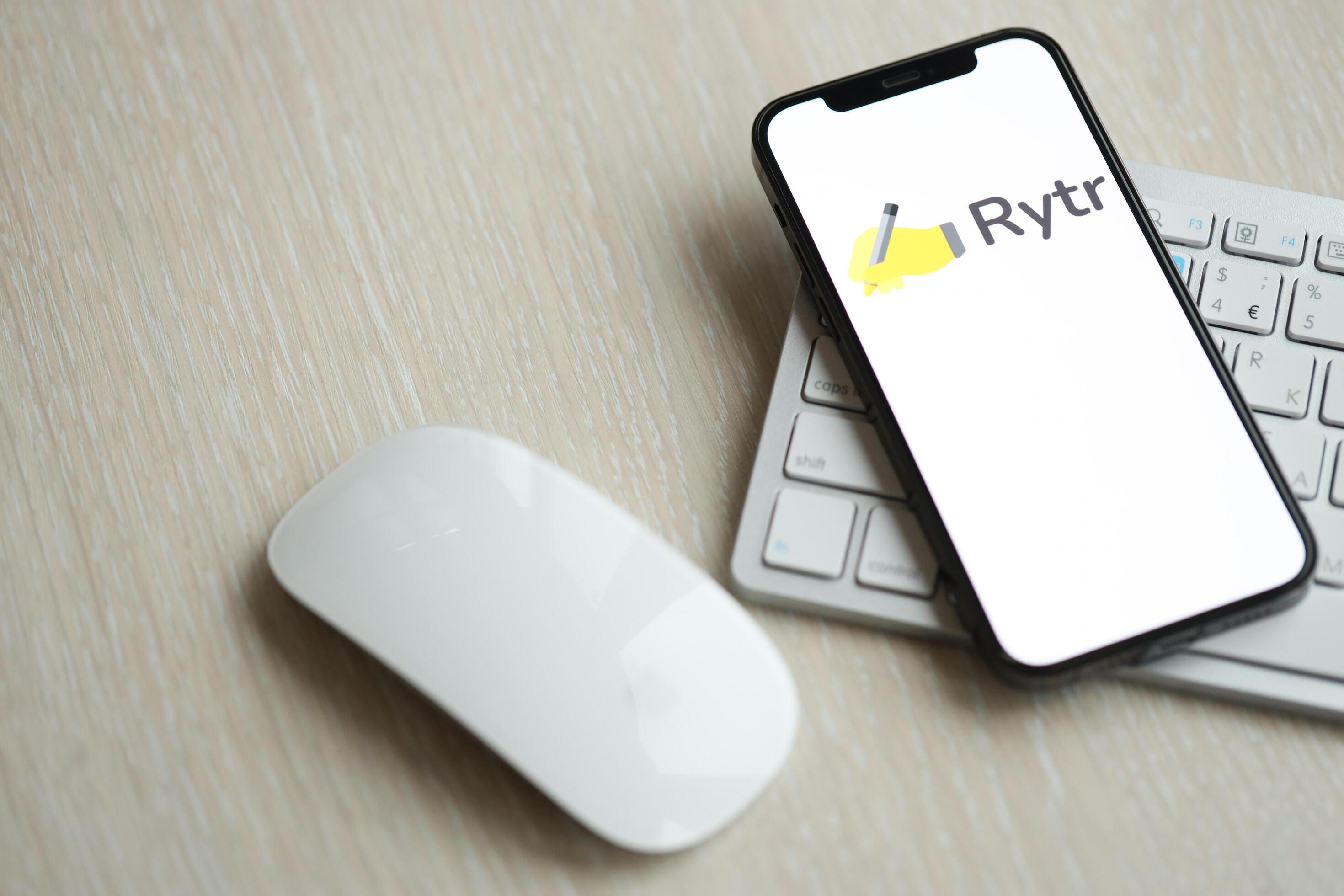 KYIV, UKRAINE - MARCH 17, 2024 Rytr logo on iPhone display screen with apple keyboard and mouse ...