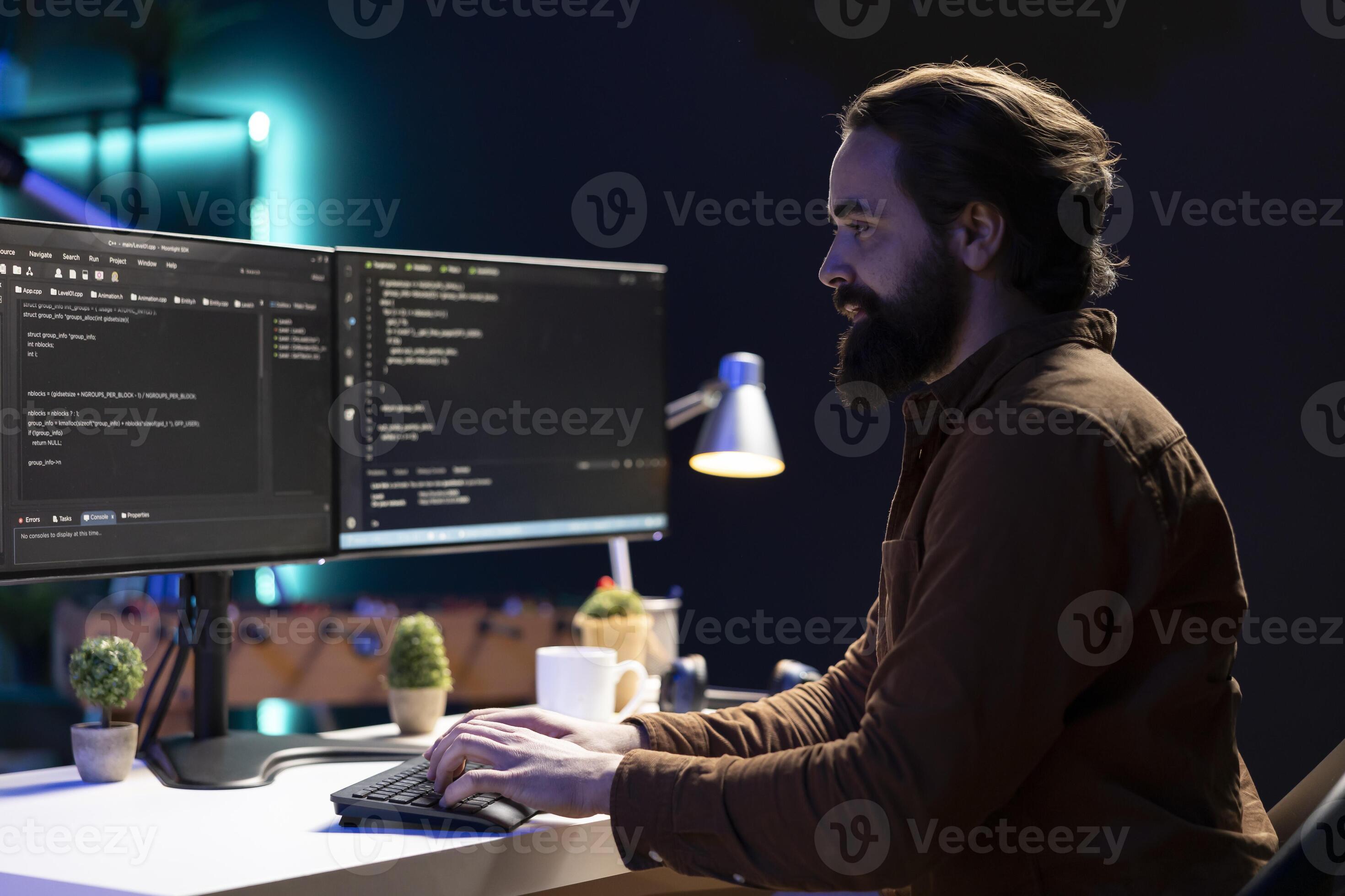 Freelancing computer engineer typing on keyboard, implementing security measures to protect ...
