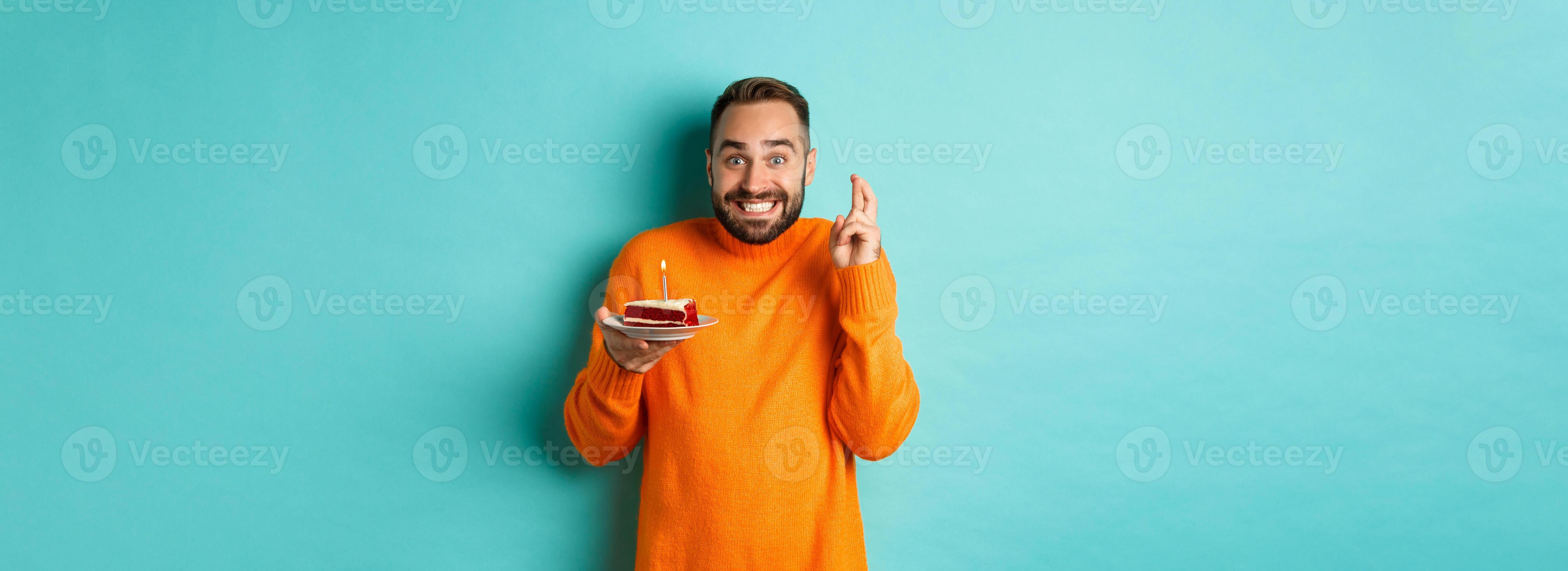 Handsome Adult Man Celebrating Birthday Blowing Out Candle On Cake And Making Wish Standing