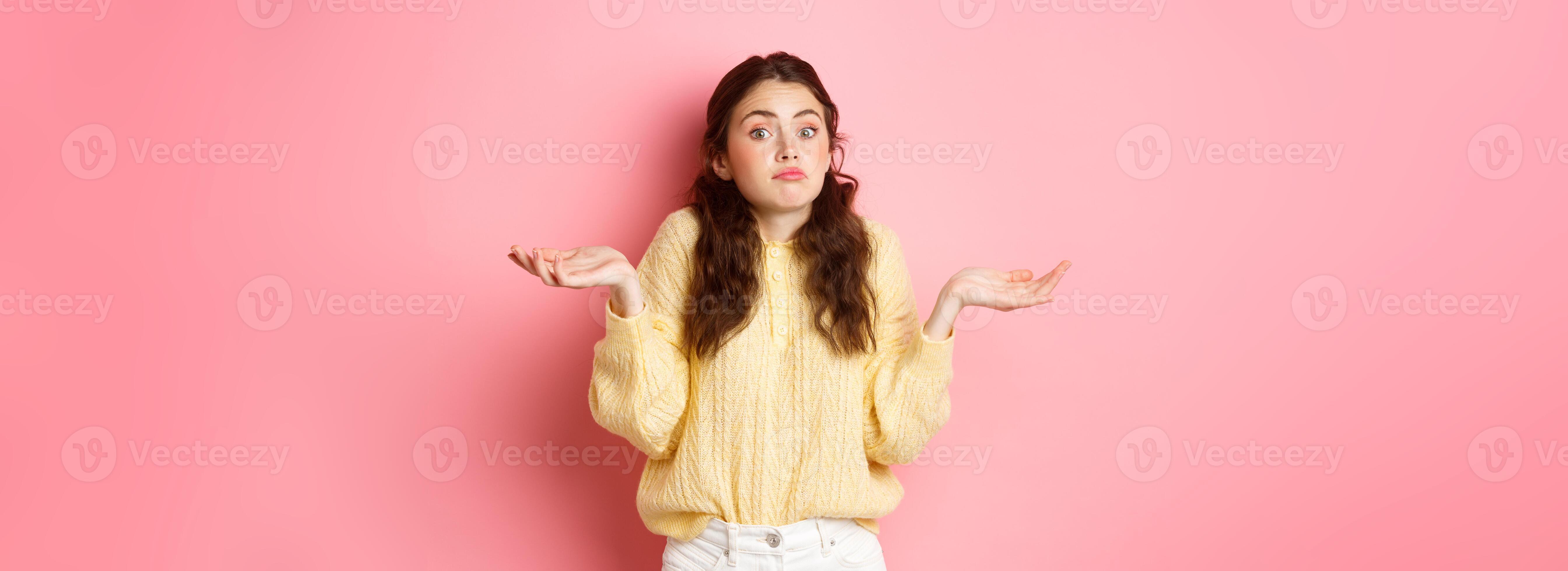 I dont know. Indecisive girl shrugging shoulders and looking unaware at ...