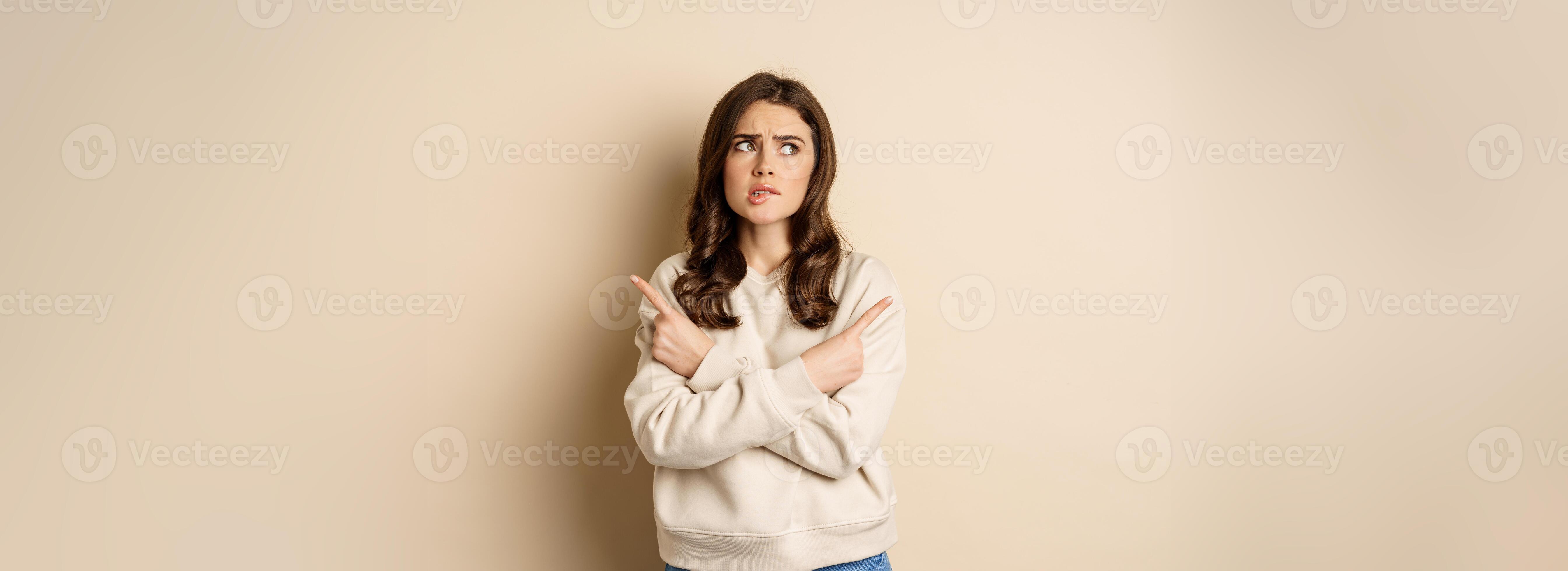Complicated and indecisive woman pointing sideways, cant make choice, struggle with decision ...