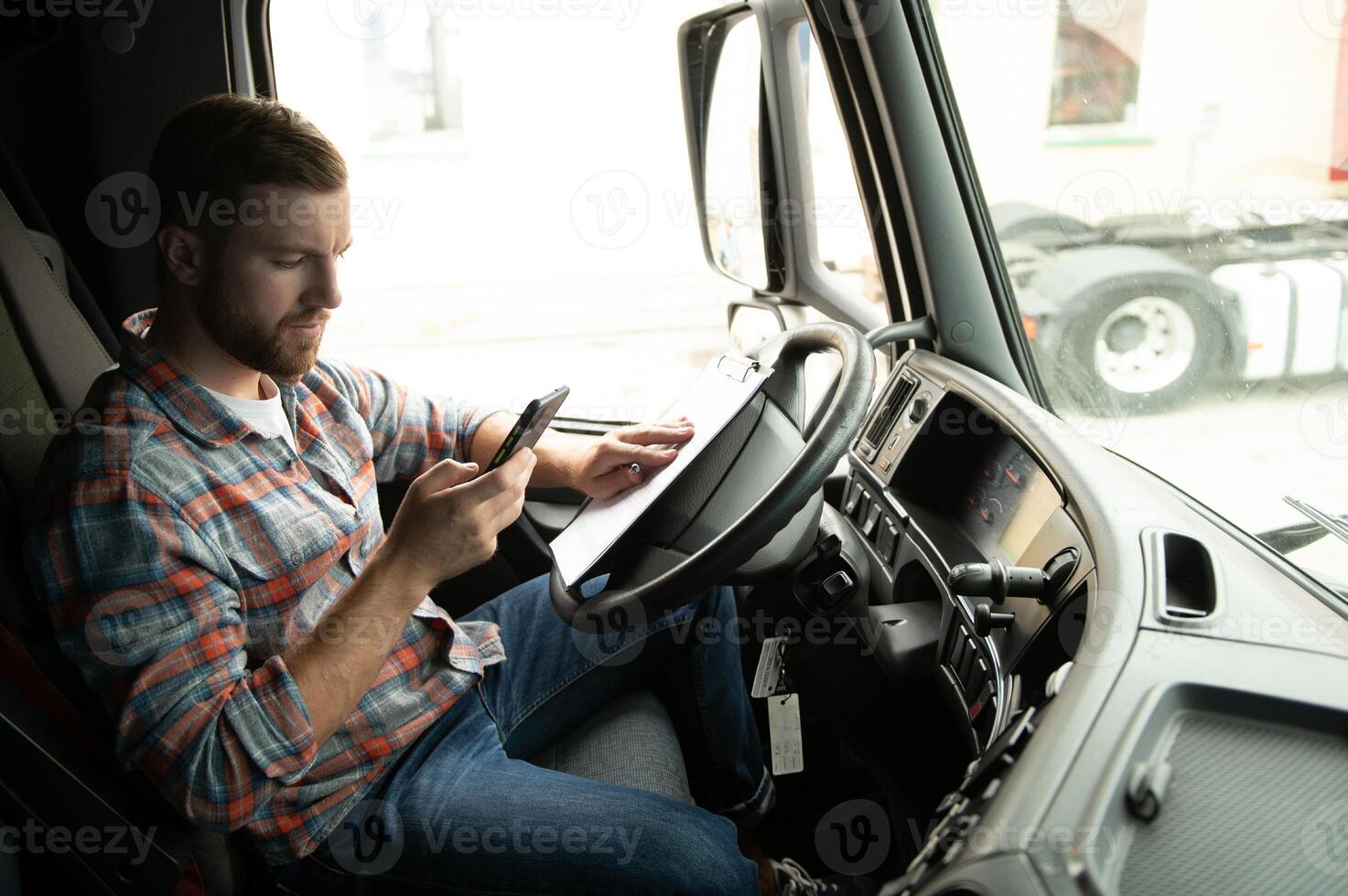 Young professional driver communicating over mobile phone while driving ...