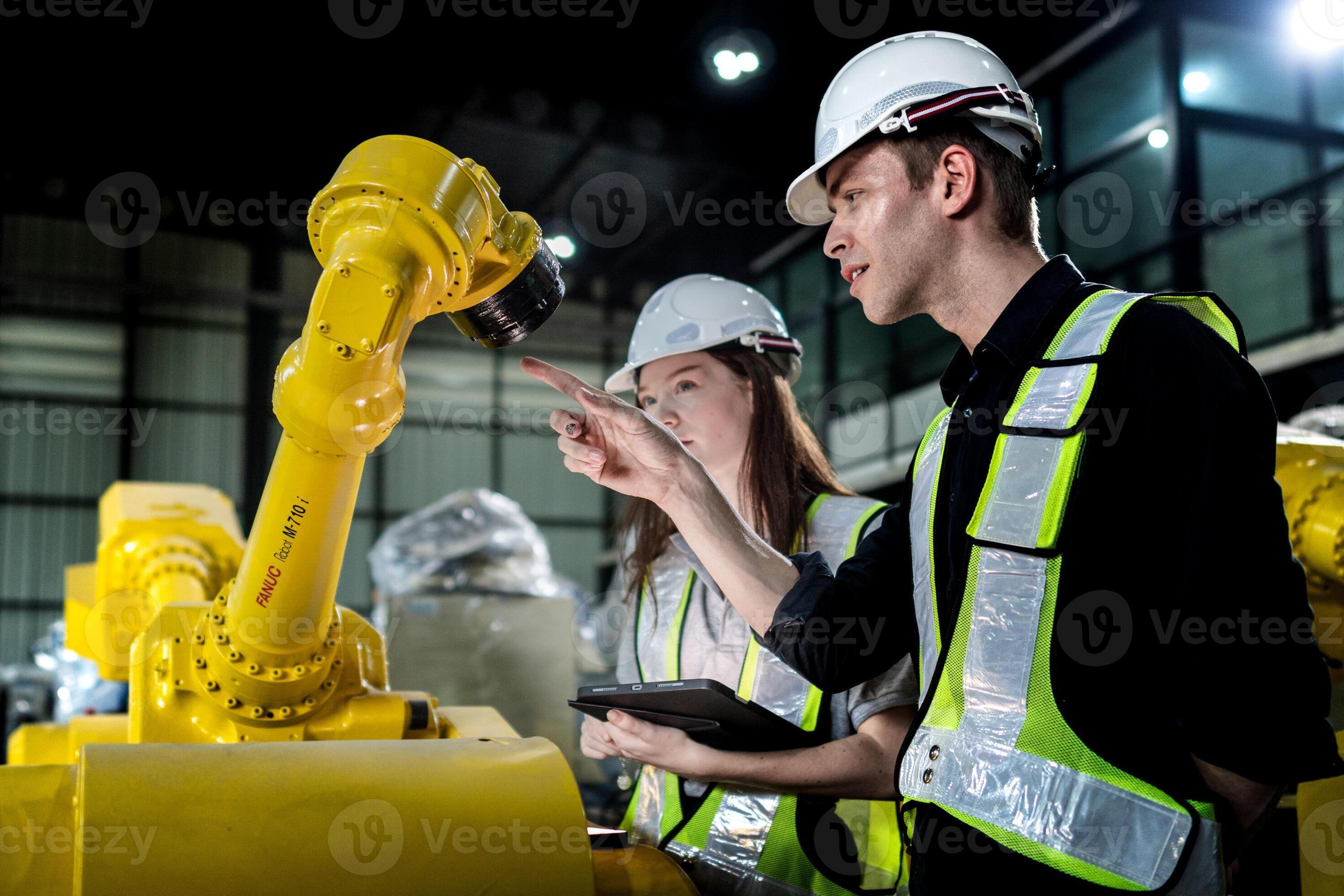 team engineers inspecting on machine with smart tablet. Worker works at ...