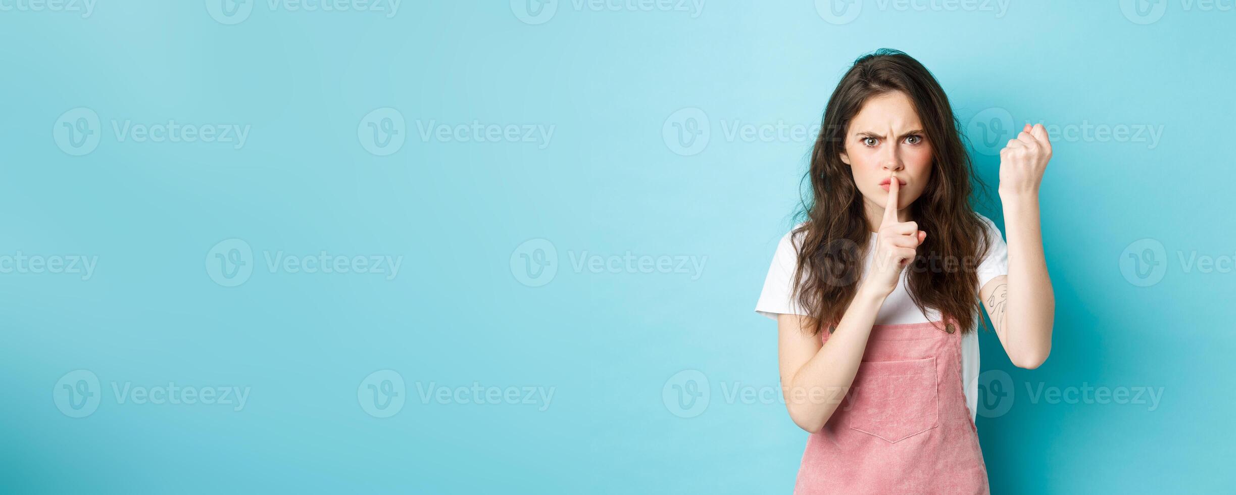 Serious and angry brunette girl shaking fist and frowning with ...