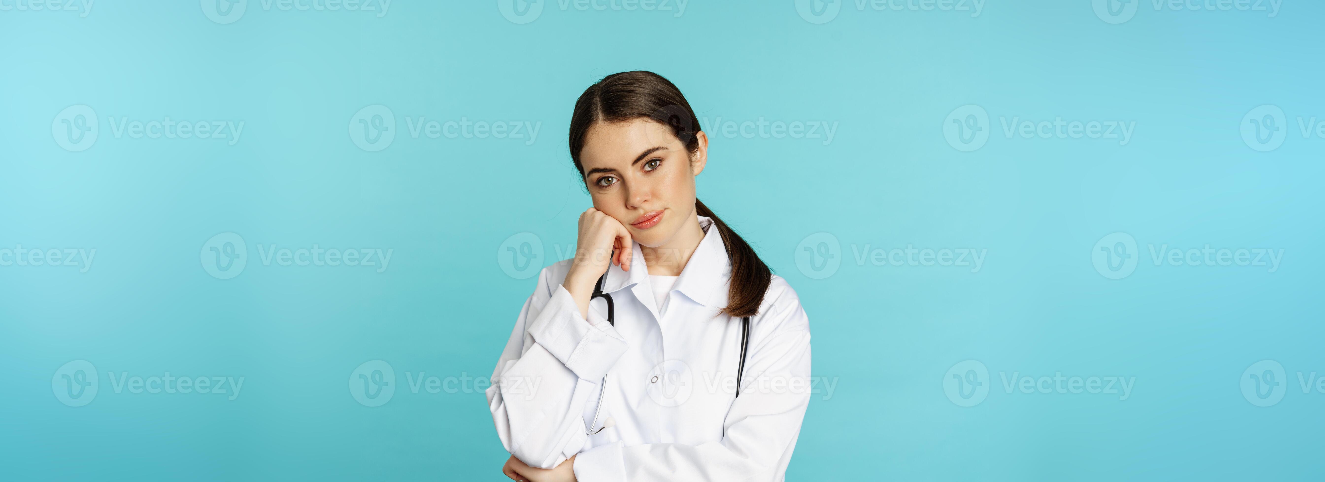 Thoughtful medical worker, young doctor woman looking unamused, bored ...