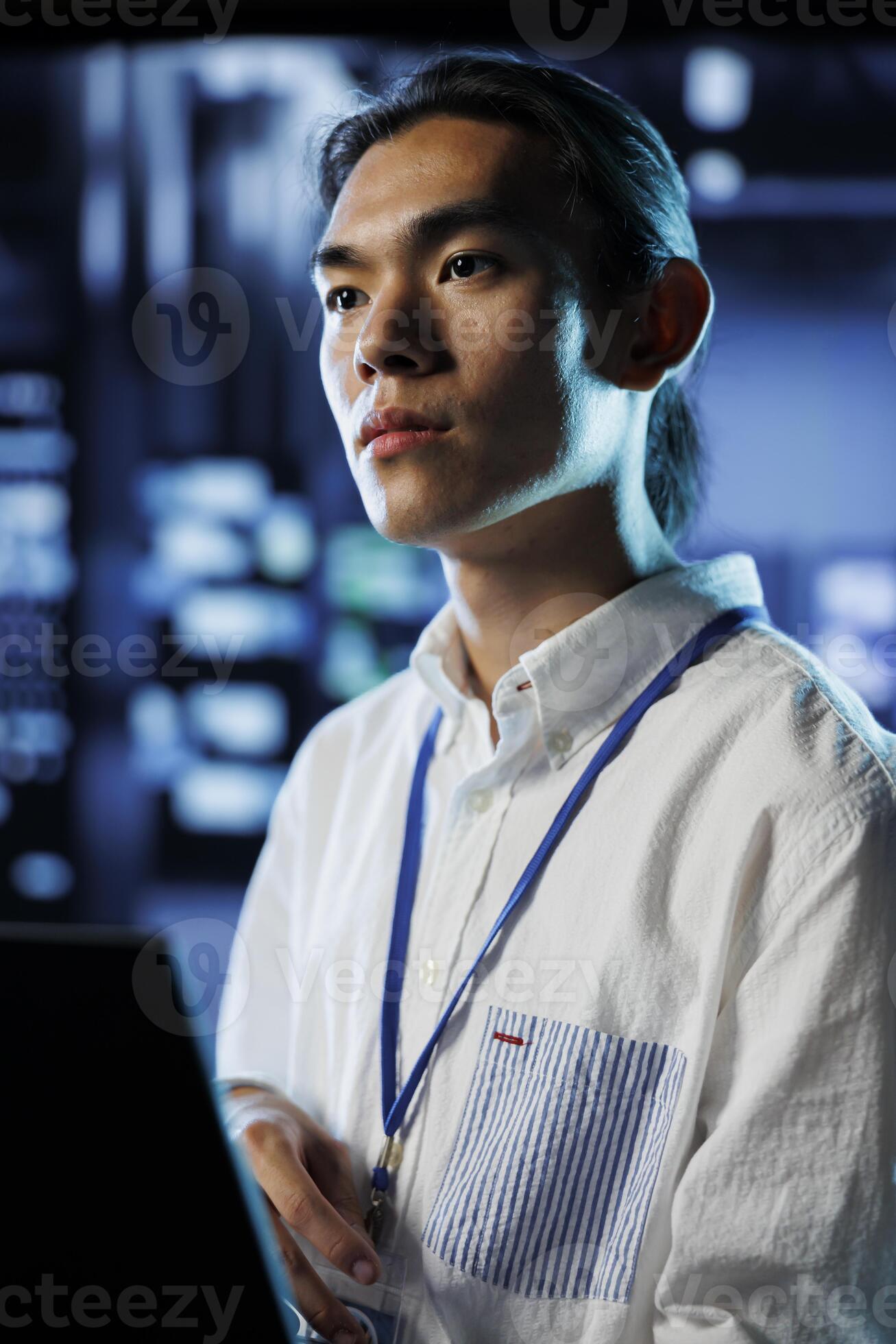 IT developer in data center uses laptop to prevent system overload during peak traffic periods ...