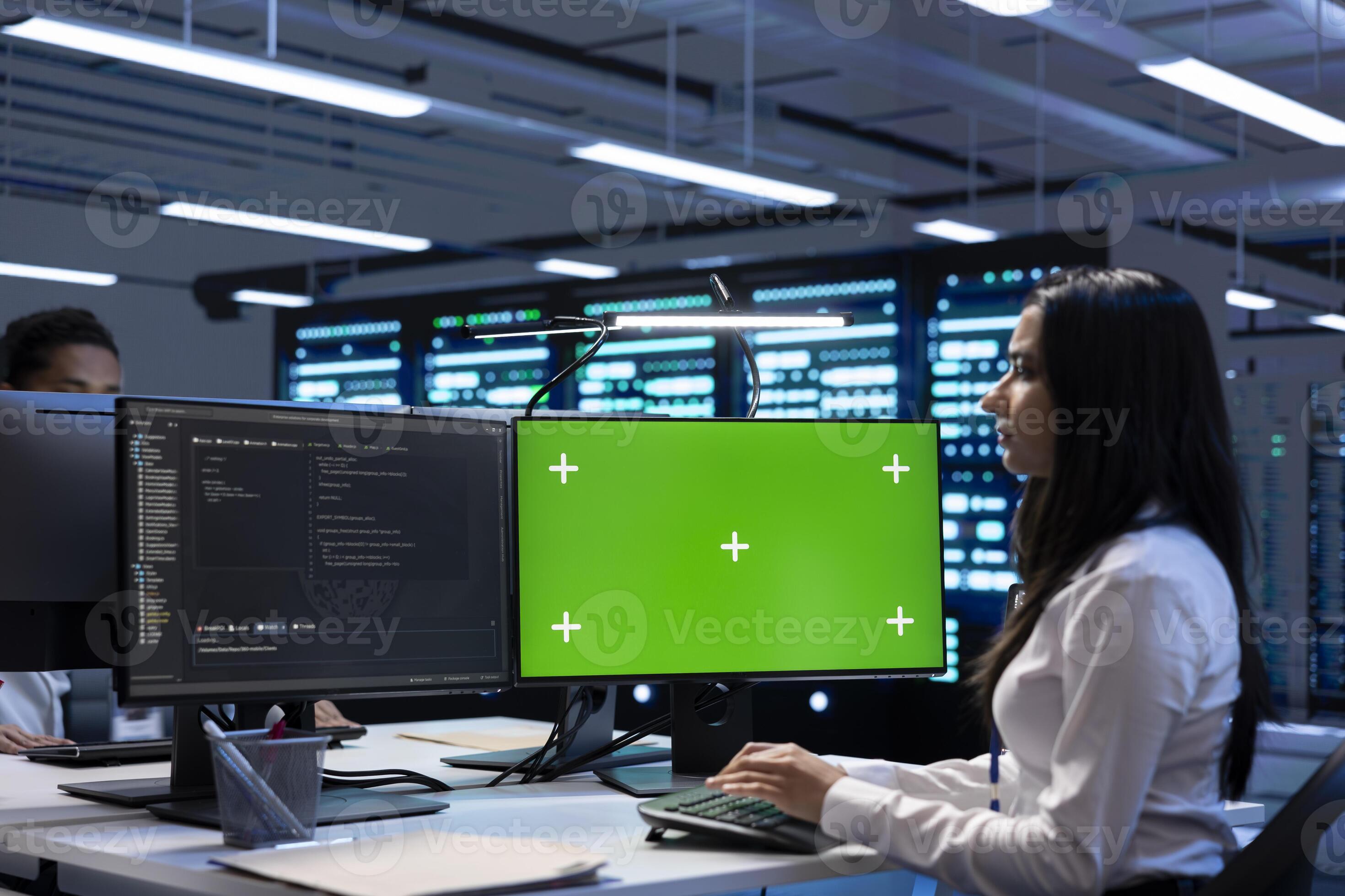 Coworkers in data center checking equipment performance on green screen computer after upgrading ...