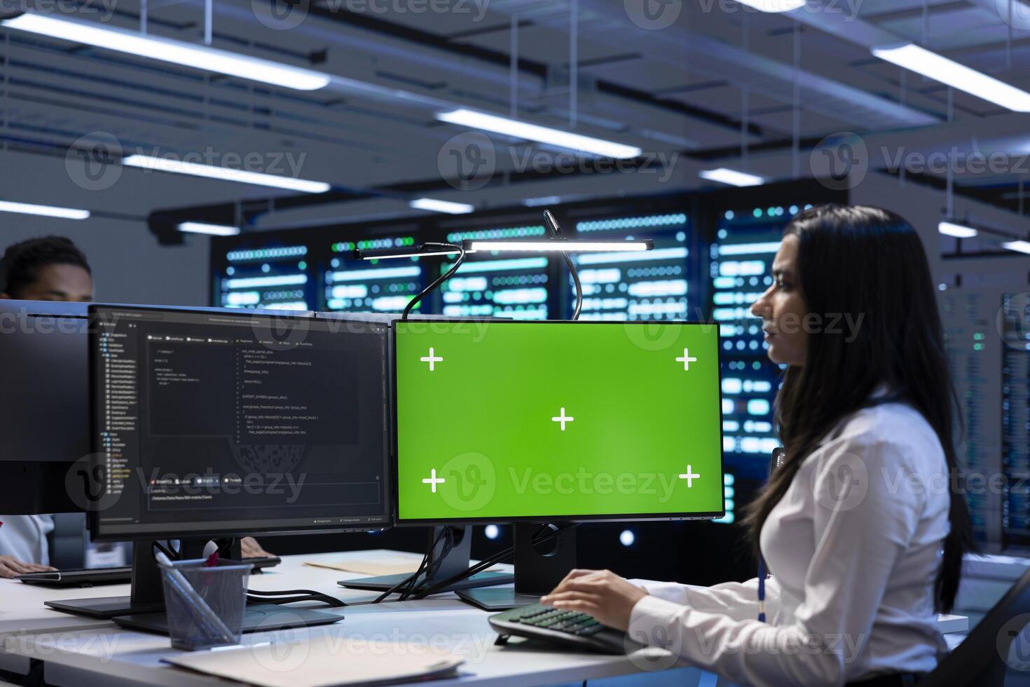 Coworkers in data center checking equipment performance on green screen computer after upgrading ...