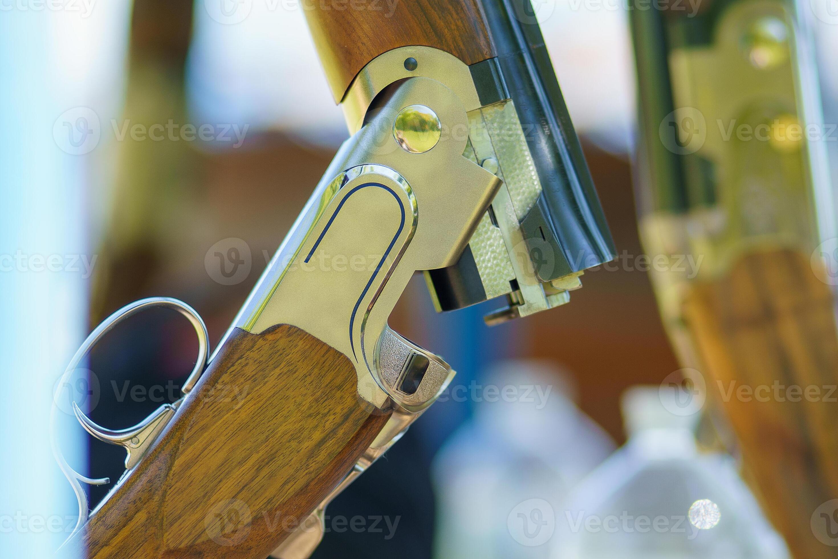 Close-up of an open, unloaded double-barreled shotgun at a sports shooting range. Blurred back ...