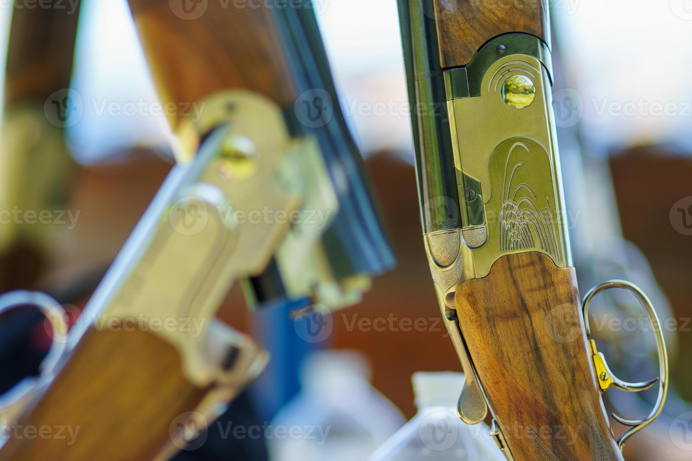 Close-up of an open, unloaded double-barreled shotgun at a sports shooting range. Blurred back ...
