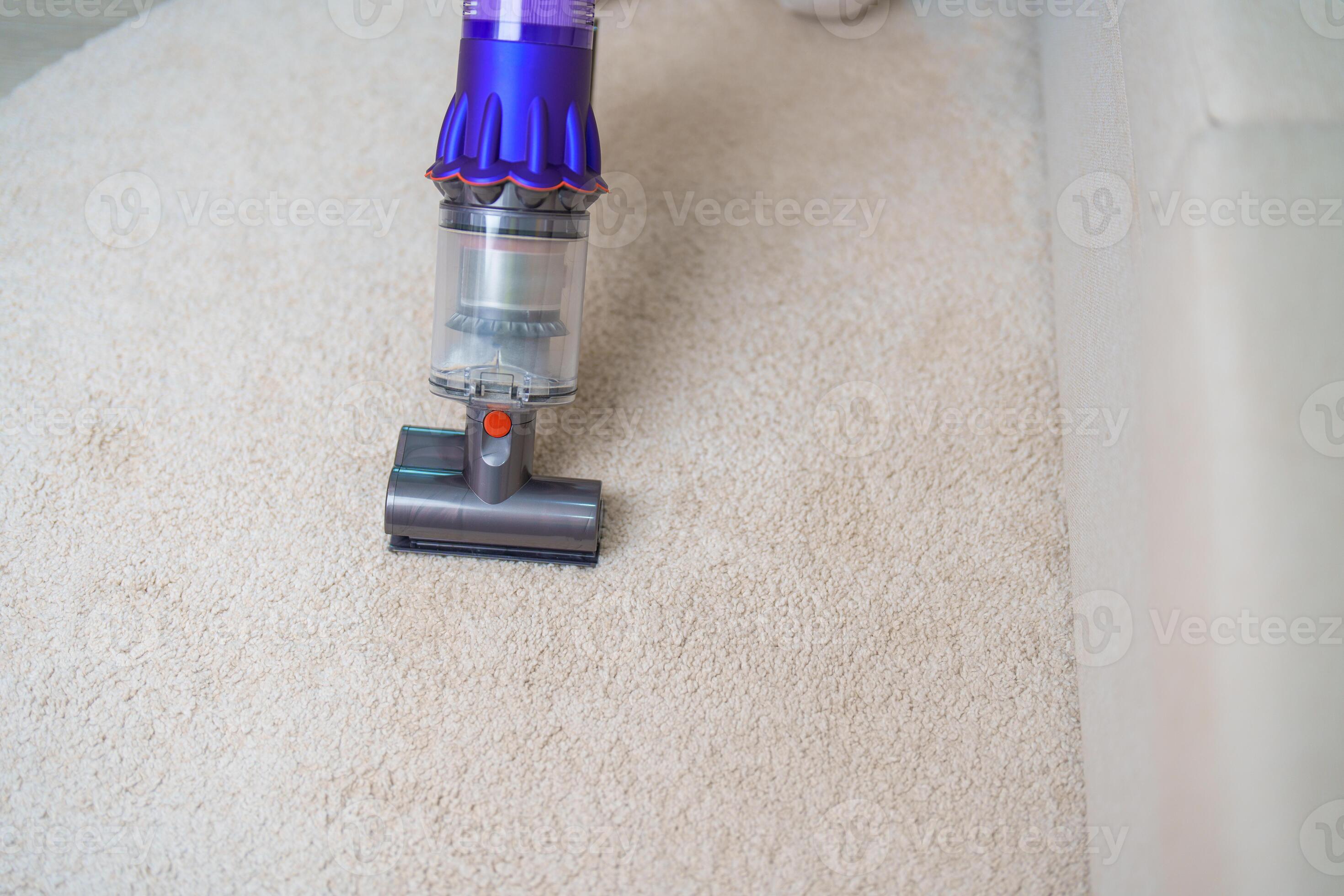 Woman cleaning Carpet with cordless Vacuum cleaner. Housewife using ...
