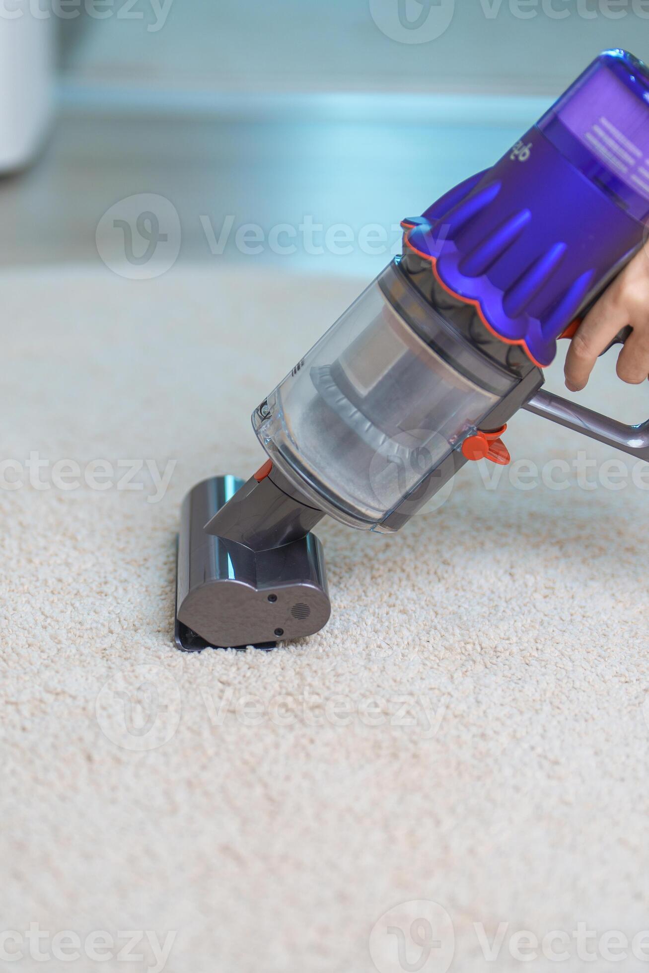 Woman cleaning Carpet with cordless Vacuum cleaner. Housewife using ...